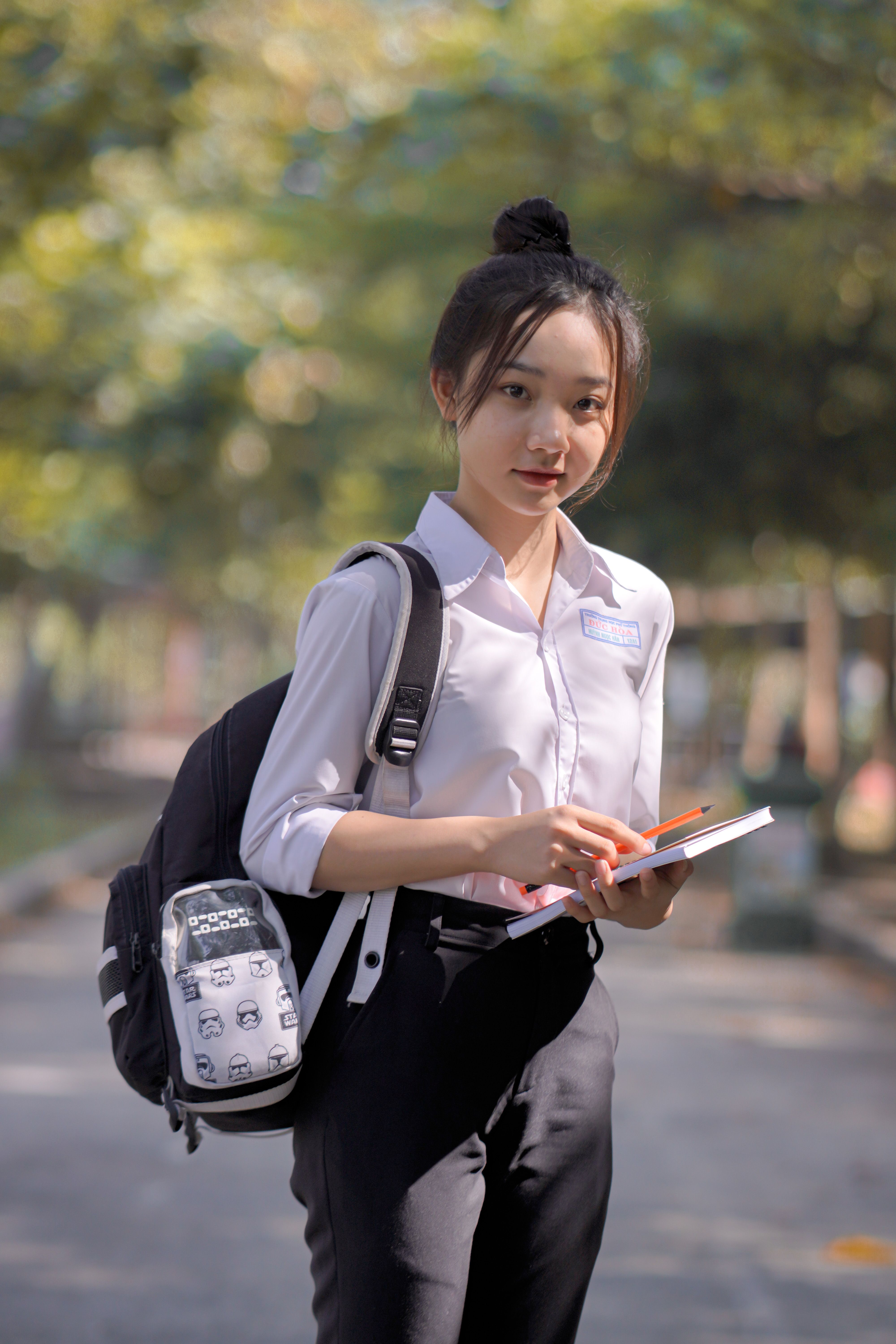 An Elegant Student Wearing a Backpack and Holding a Notebook Standing ...