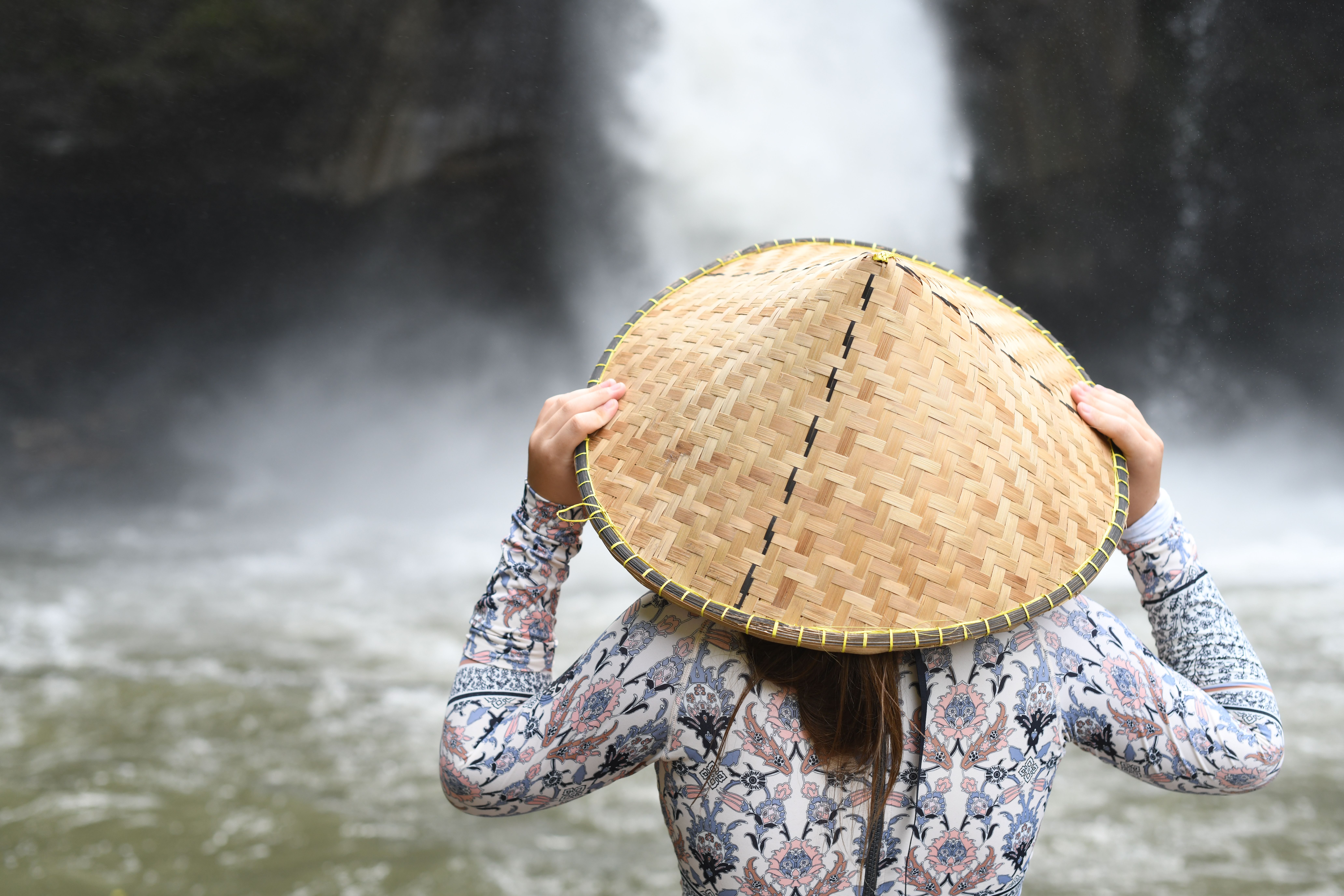 Back View of Woman in Traditional, Conical Hat Standing by Waterfall ...