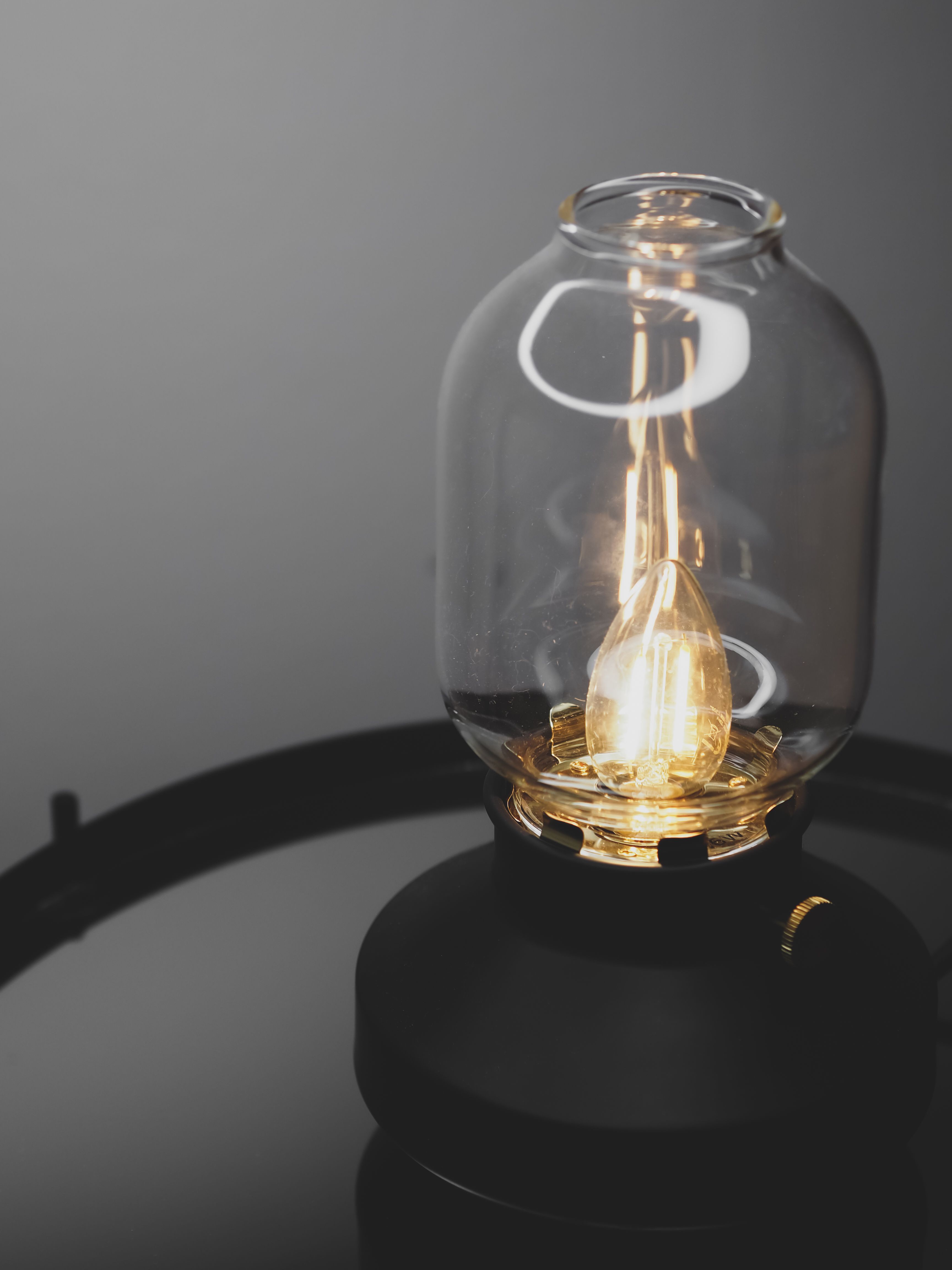 A lamp with a glass bulb on top of a table · Free Stock Photo