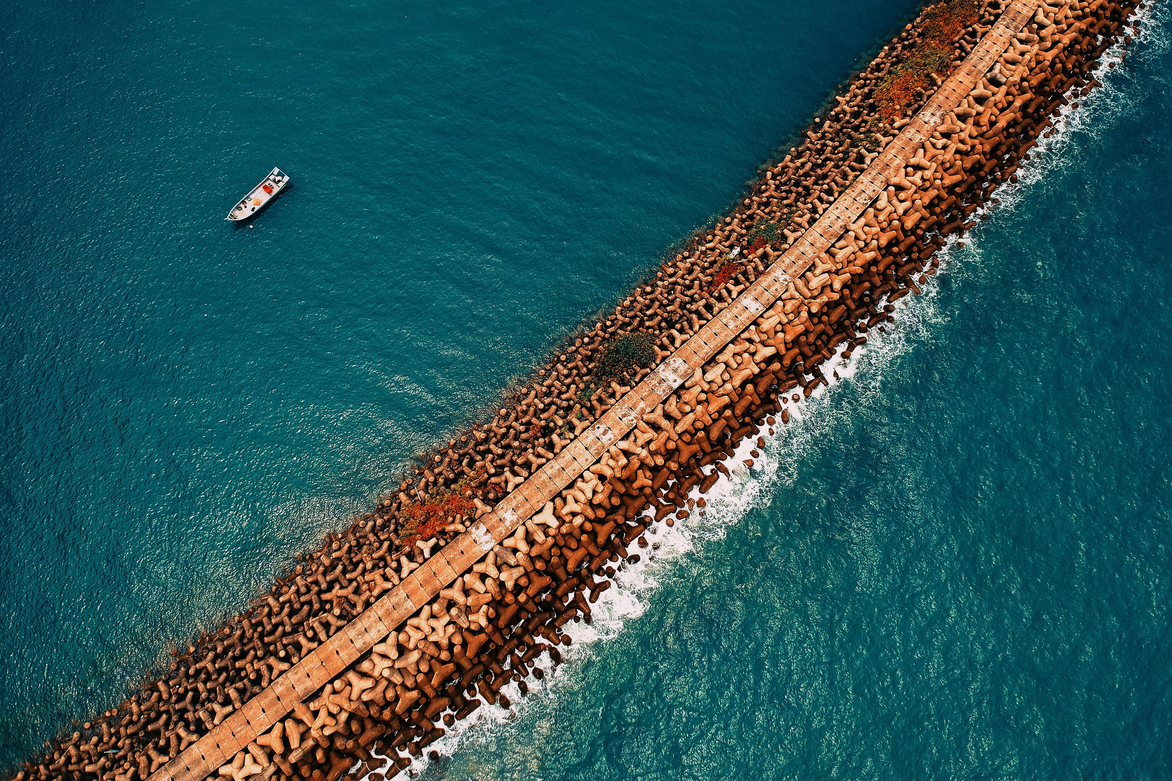 Ship on Body of Water Near Rock Formation · Free Stock Photo