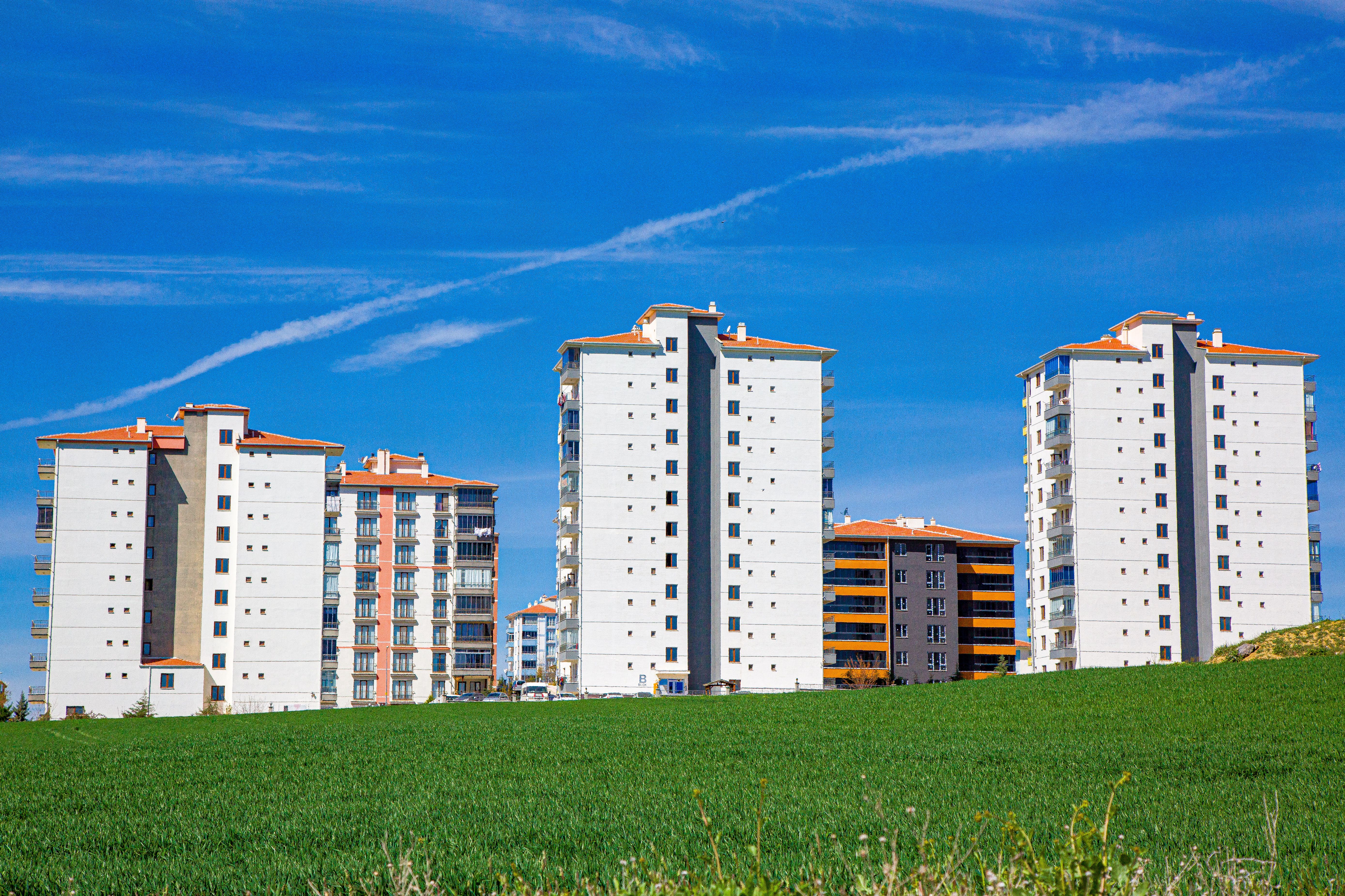 A large green field with a few buildings in the background · Free Stock ...