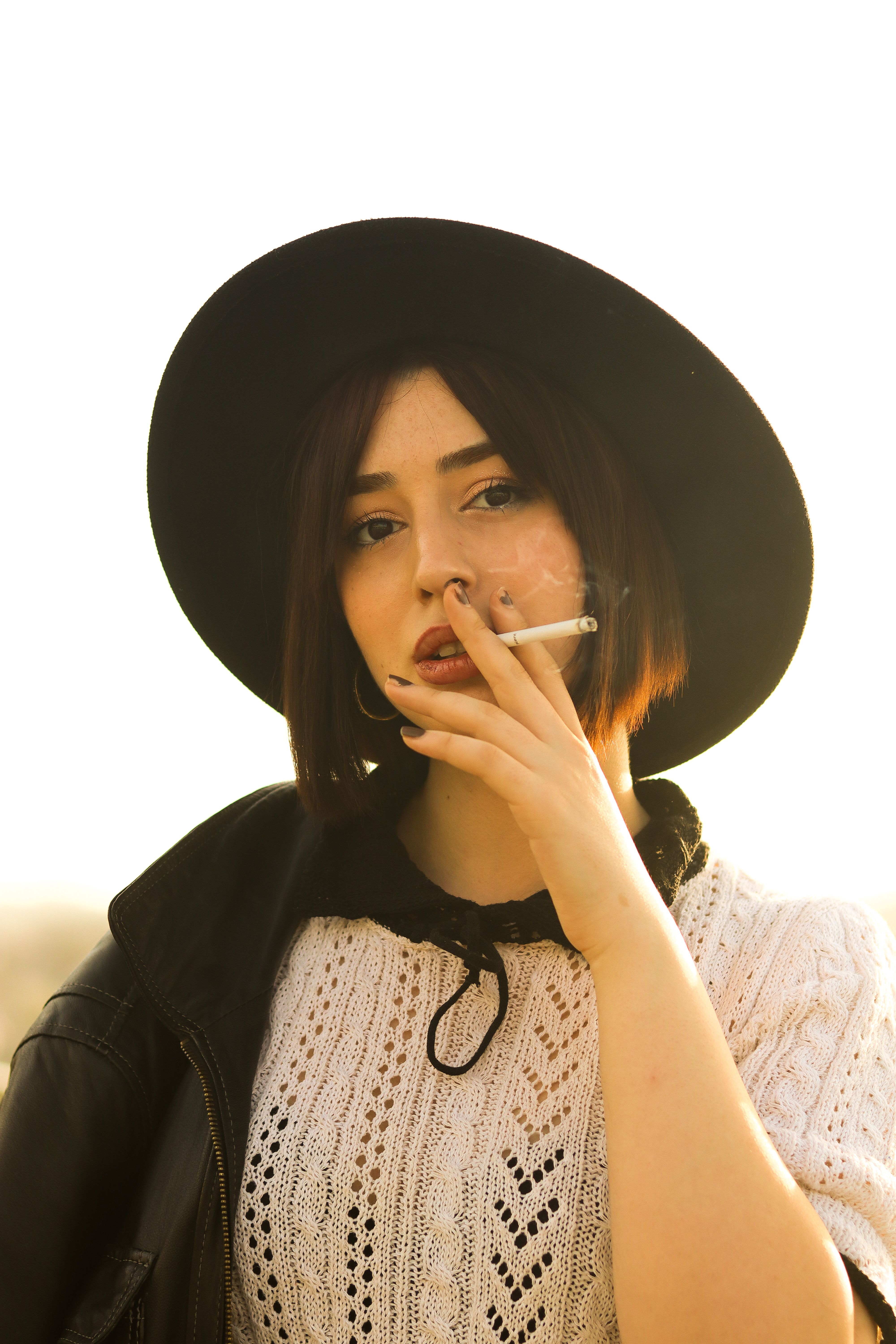 A Fashionable Woman Smoking a Cigarette Outside · Free Stock Photo