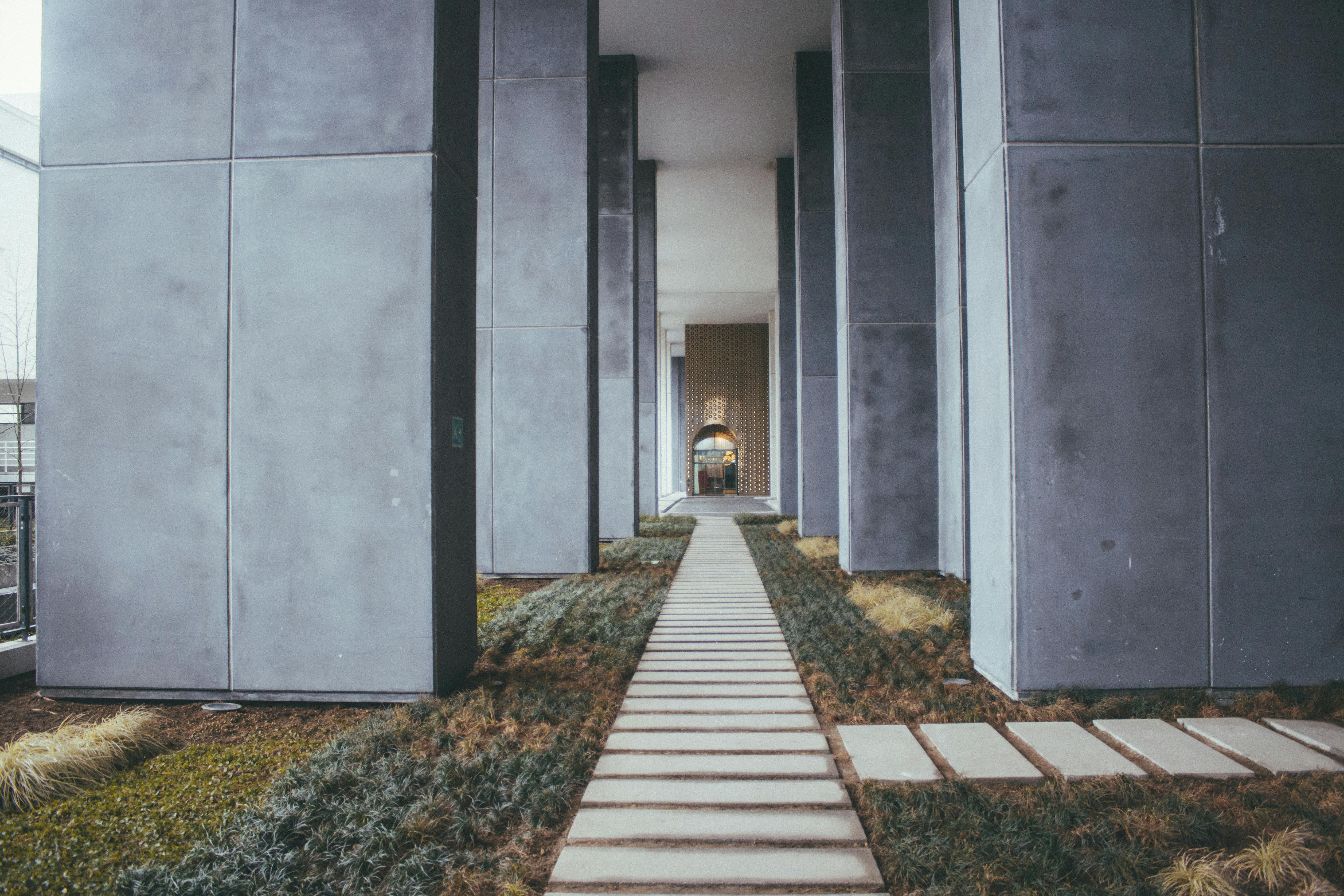 Narrow Pathway Between Concrete Columns · Free Stock Photo