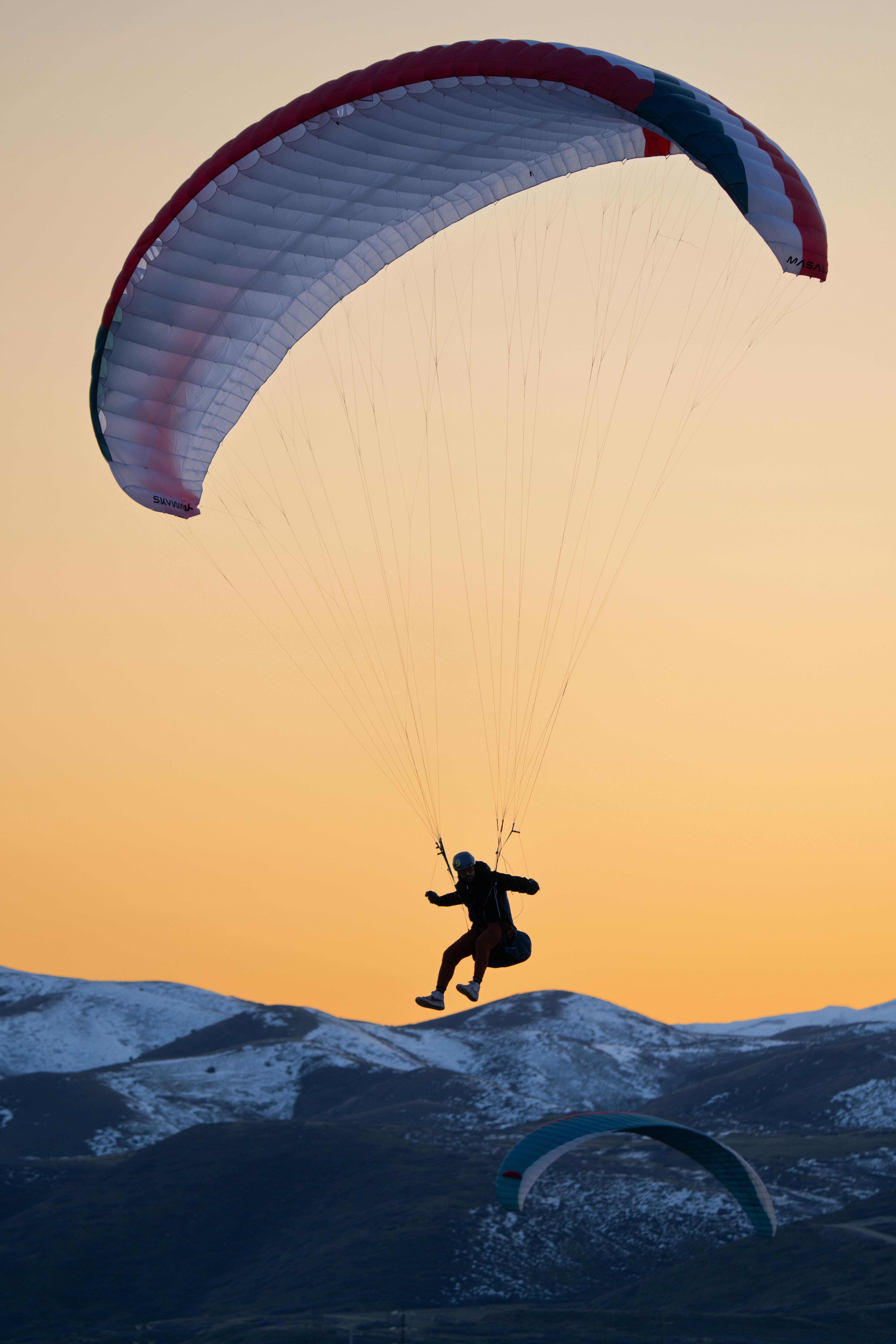 Person Flying with Parachute at Sunset · Free Stock Photo
