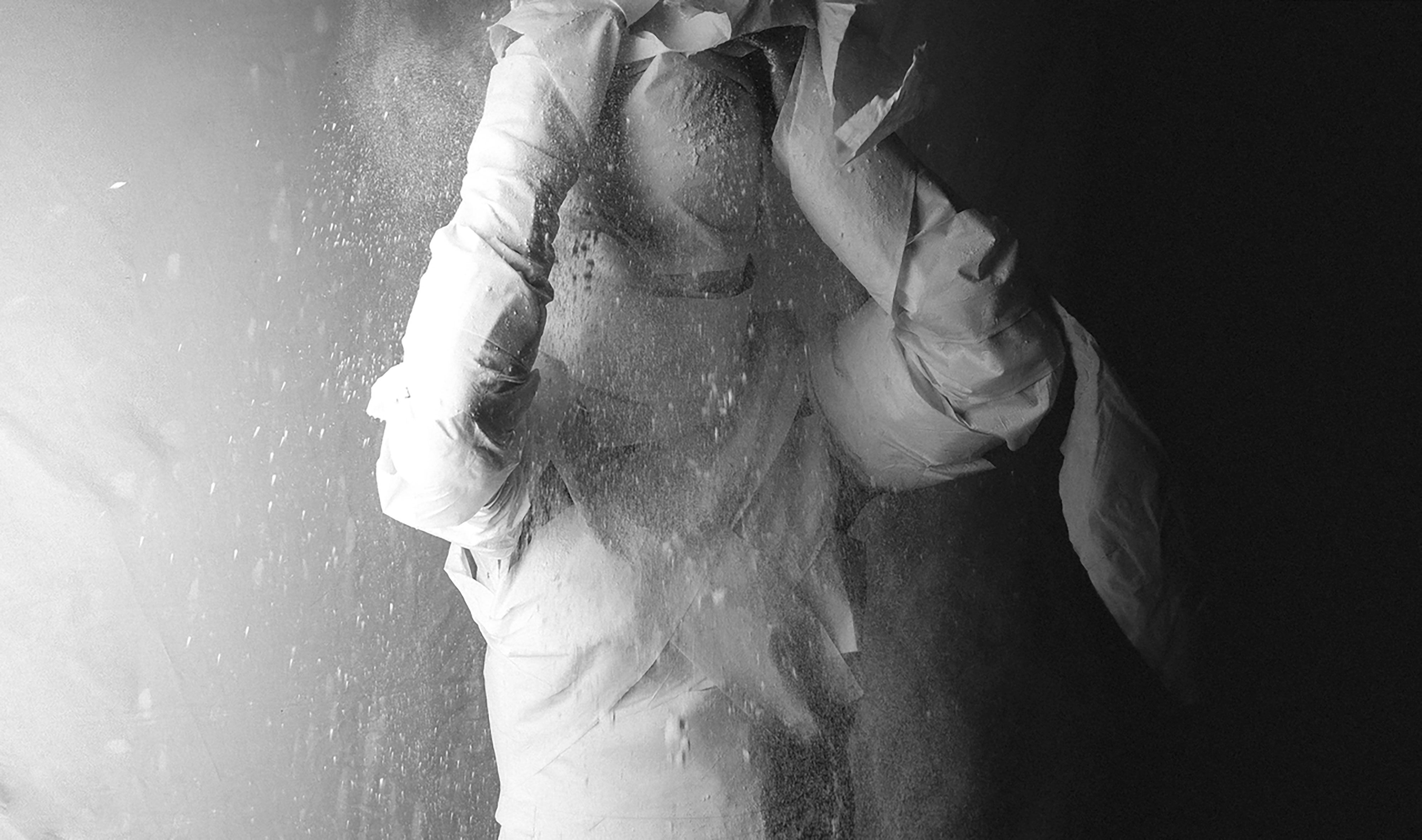 Black and White Photo of a Person Wrapped in Paper Throwing Dirt on ...
