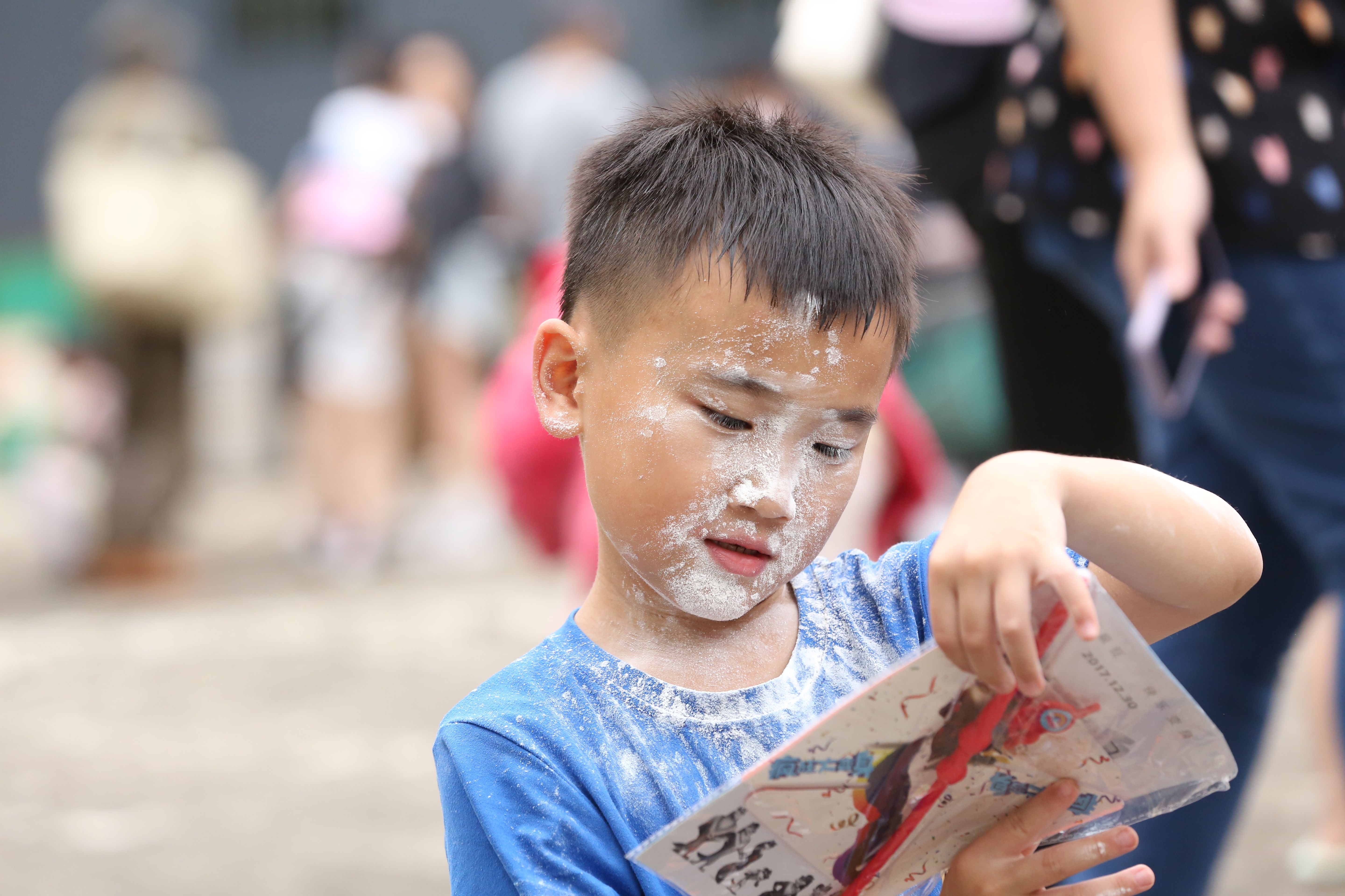 A Little Boy with His Face Covered in White Powder Holding a Toy · Free ...