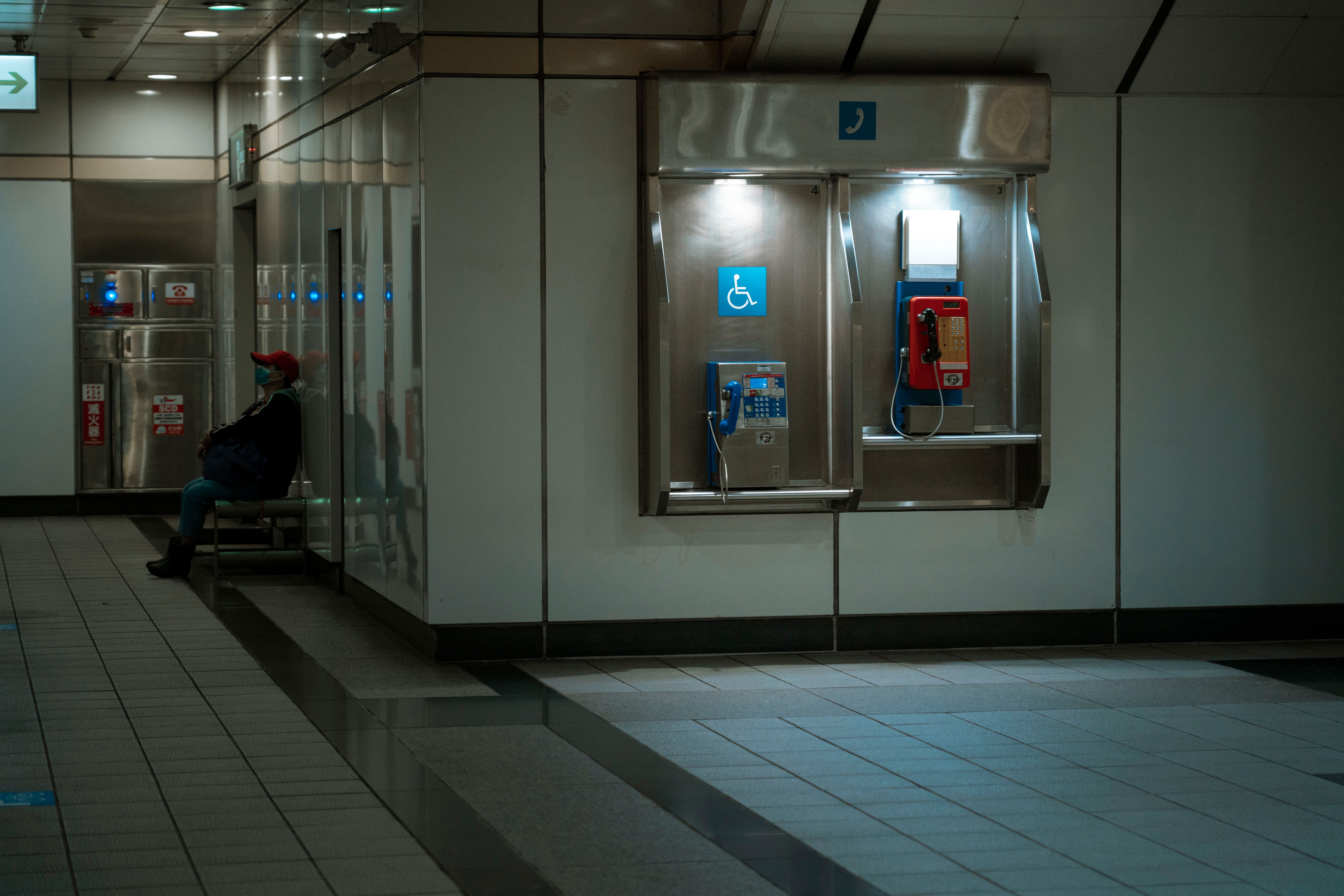 Phones Mounted on Wall of Dimly Lit Waiting Room · Free Stock Photo