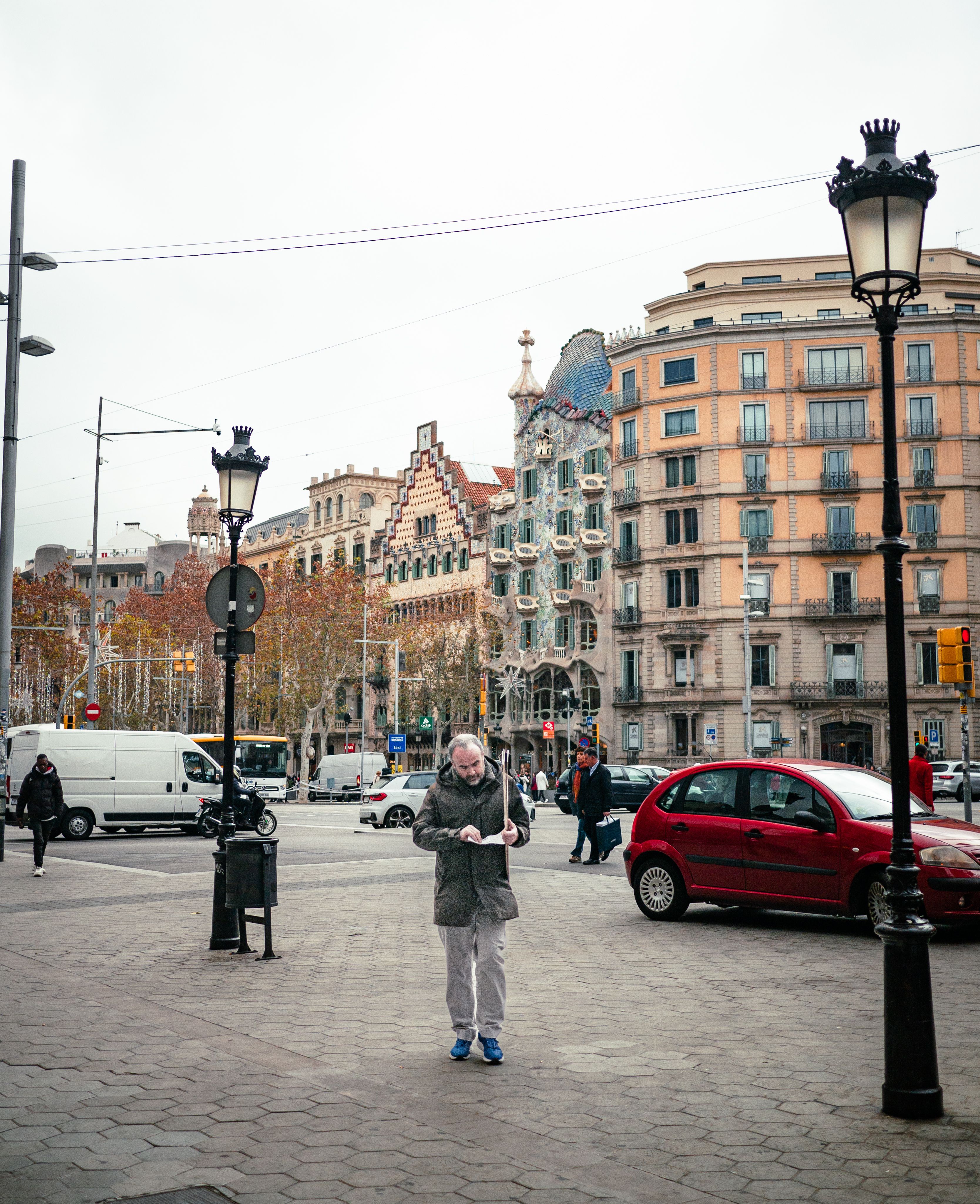 A Man Walking on a Sidewalk with View of the Casa Mila in Barcelona ...