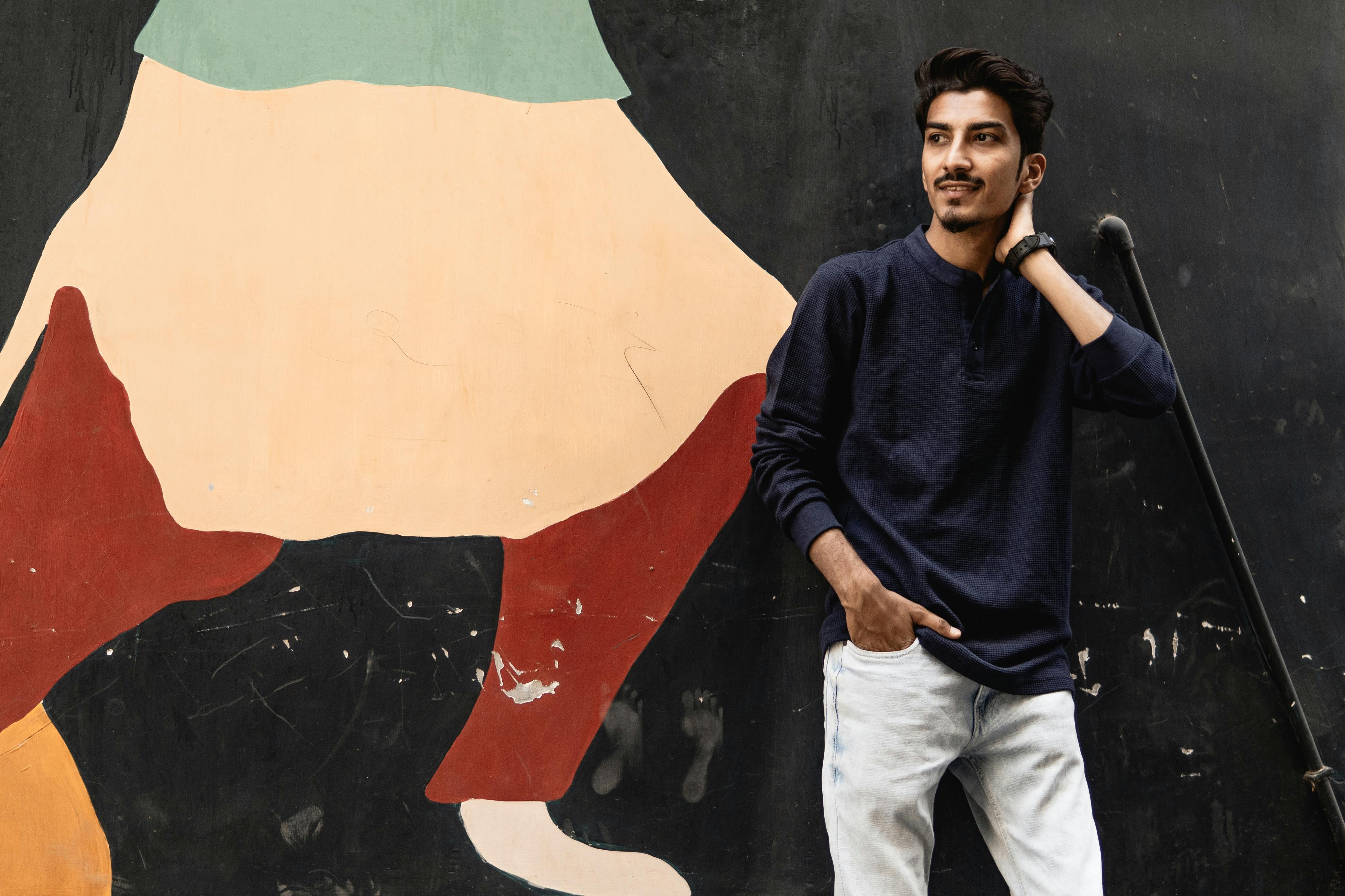 Man Posing in Front of a Painting on a Wall · Free Stock Photo