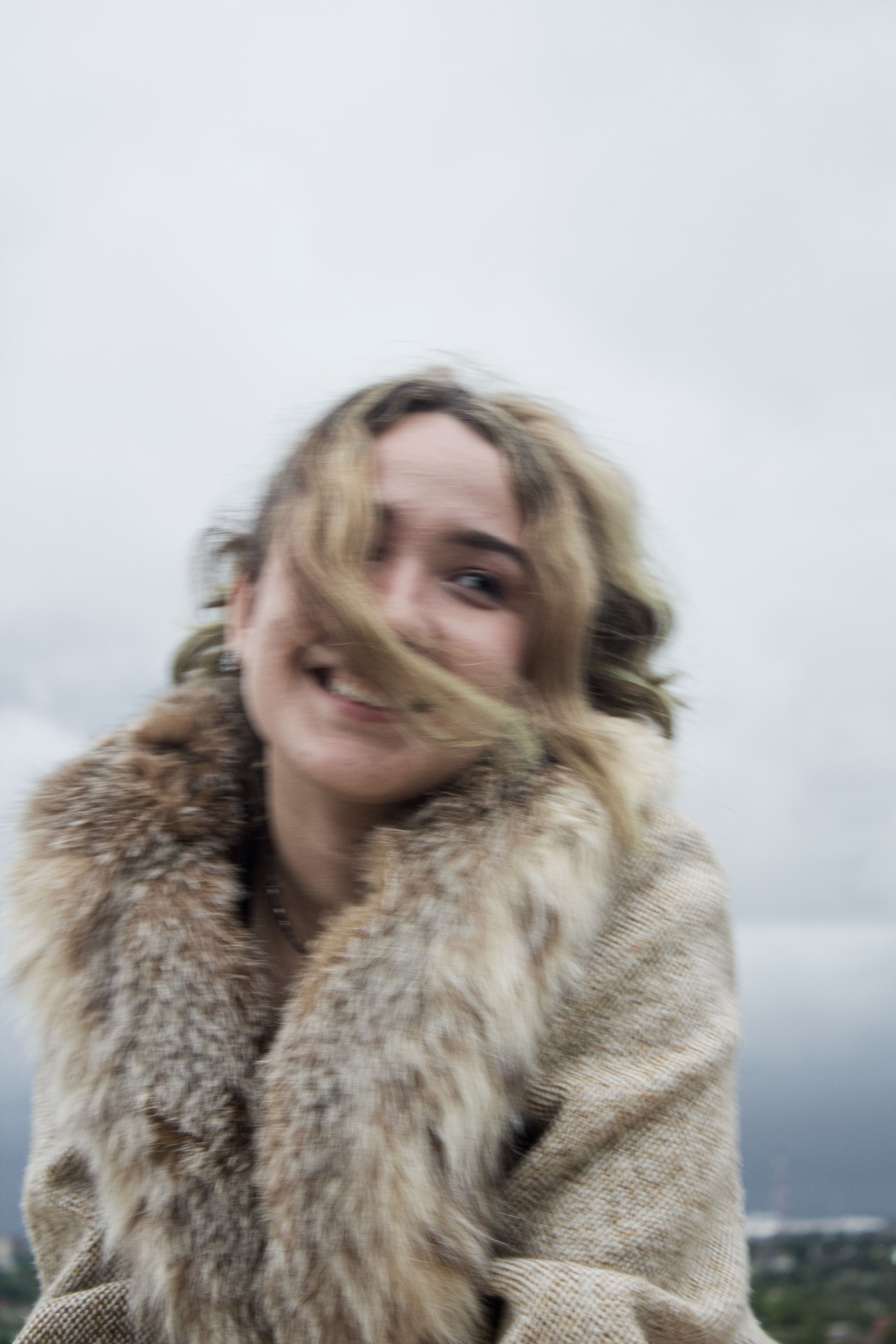 Blurry Photo of a Young Woman in a Coat Standing Outside and Smiling ...