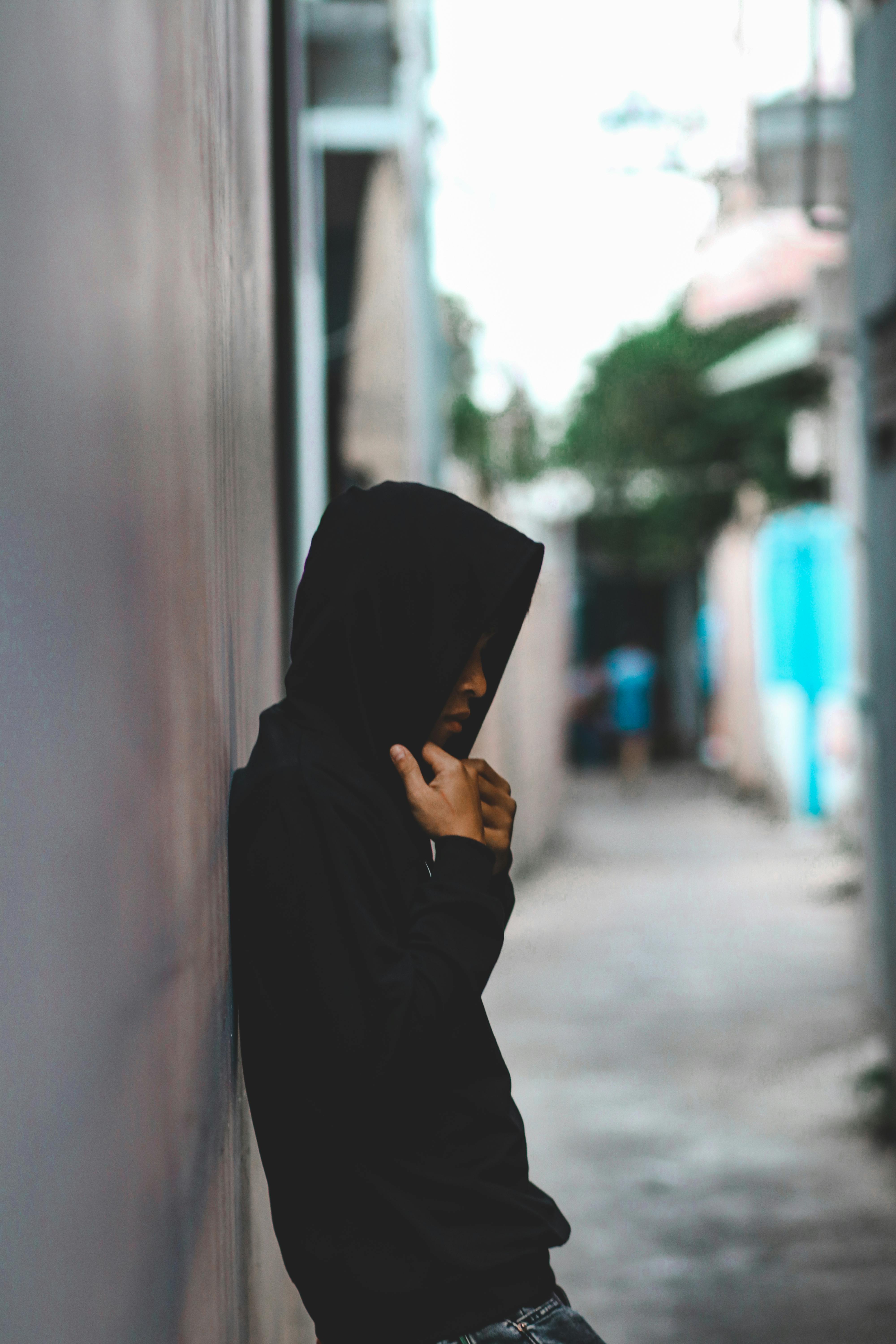 Persona Recostada En La Pared Vistiendo Chaqueta Con Capucha Negra ...