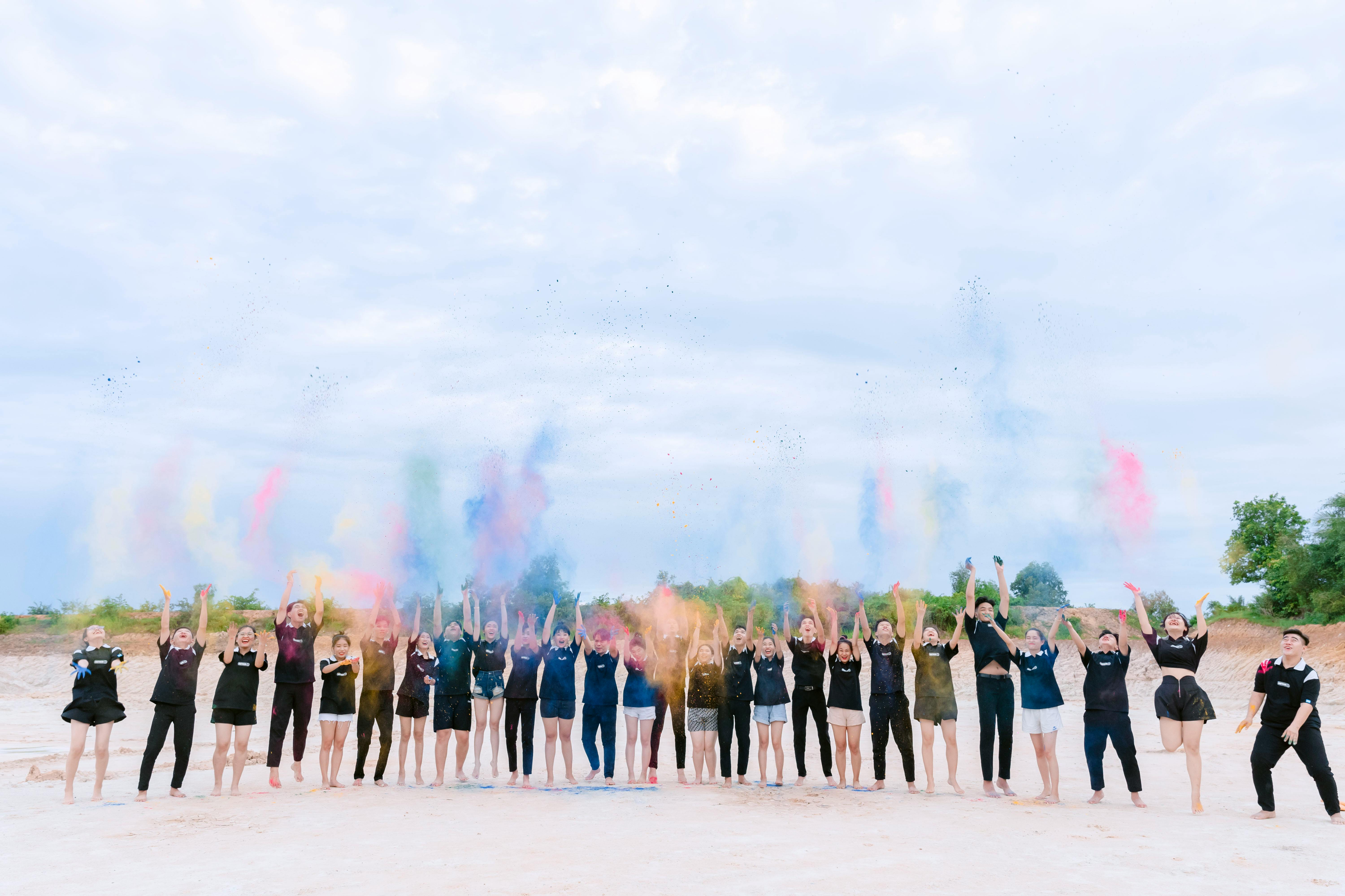Women and Men Throwing Powder on Beach · Free Stock Photo