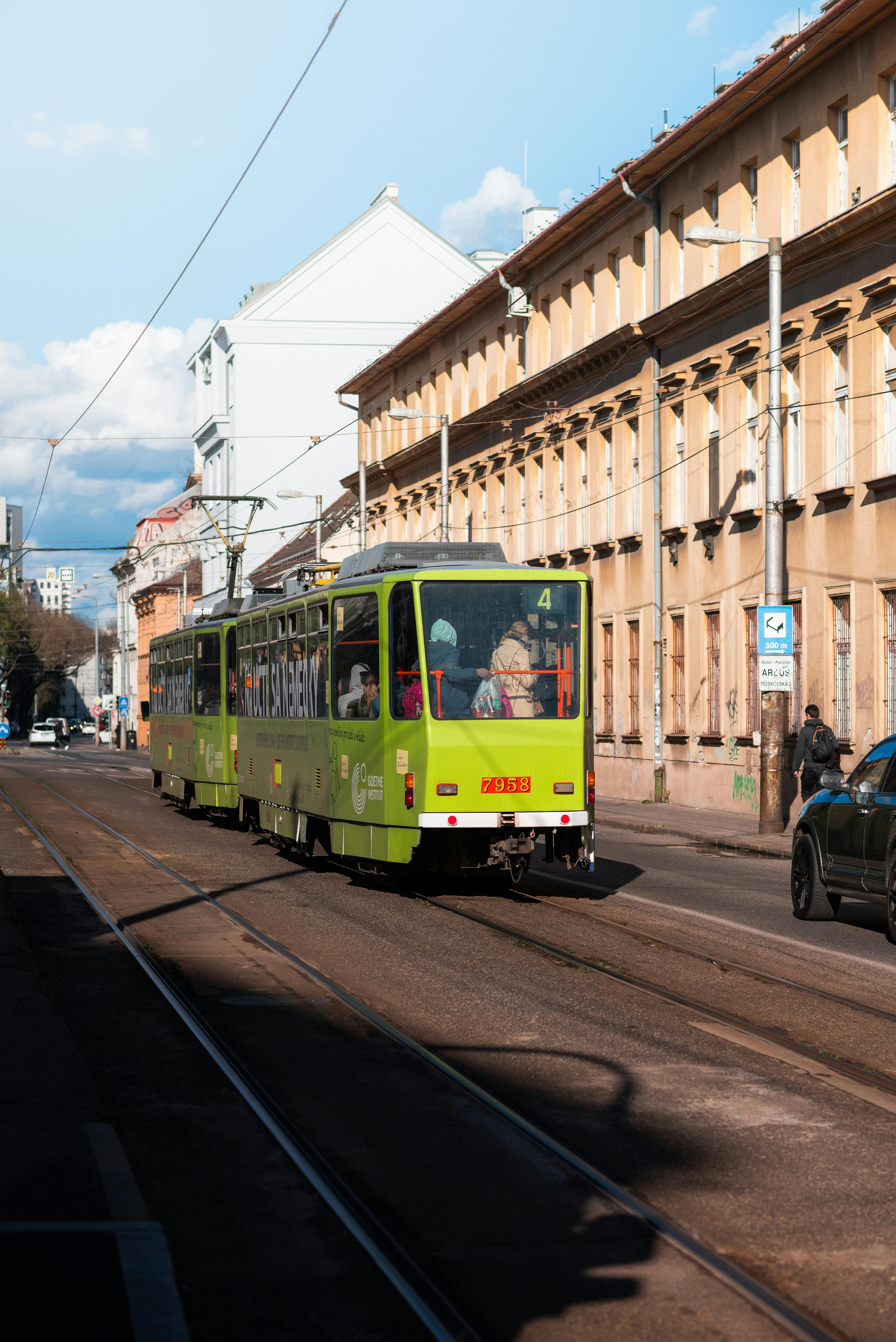 A green tram on a city street · Free Stock Photo