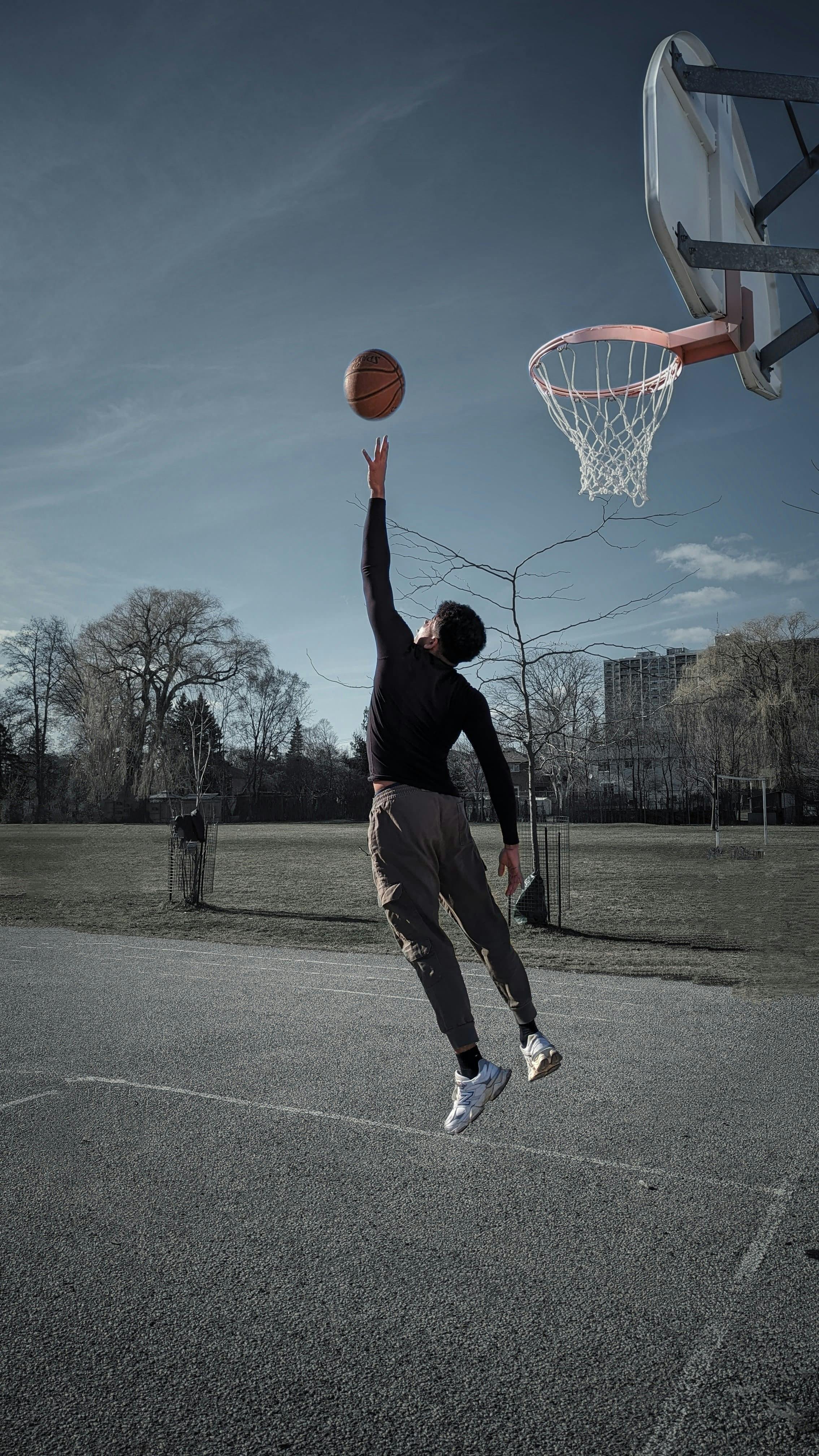 Man Trying to Reach Ball in Air on Basketball Court · Free Stock Photo