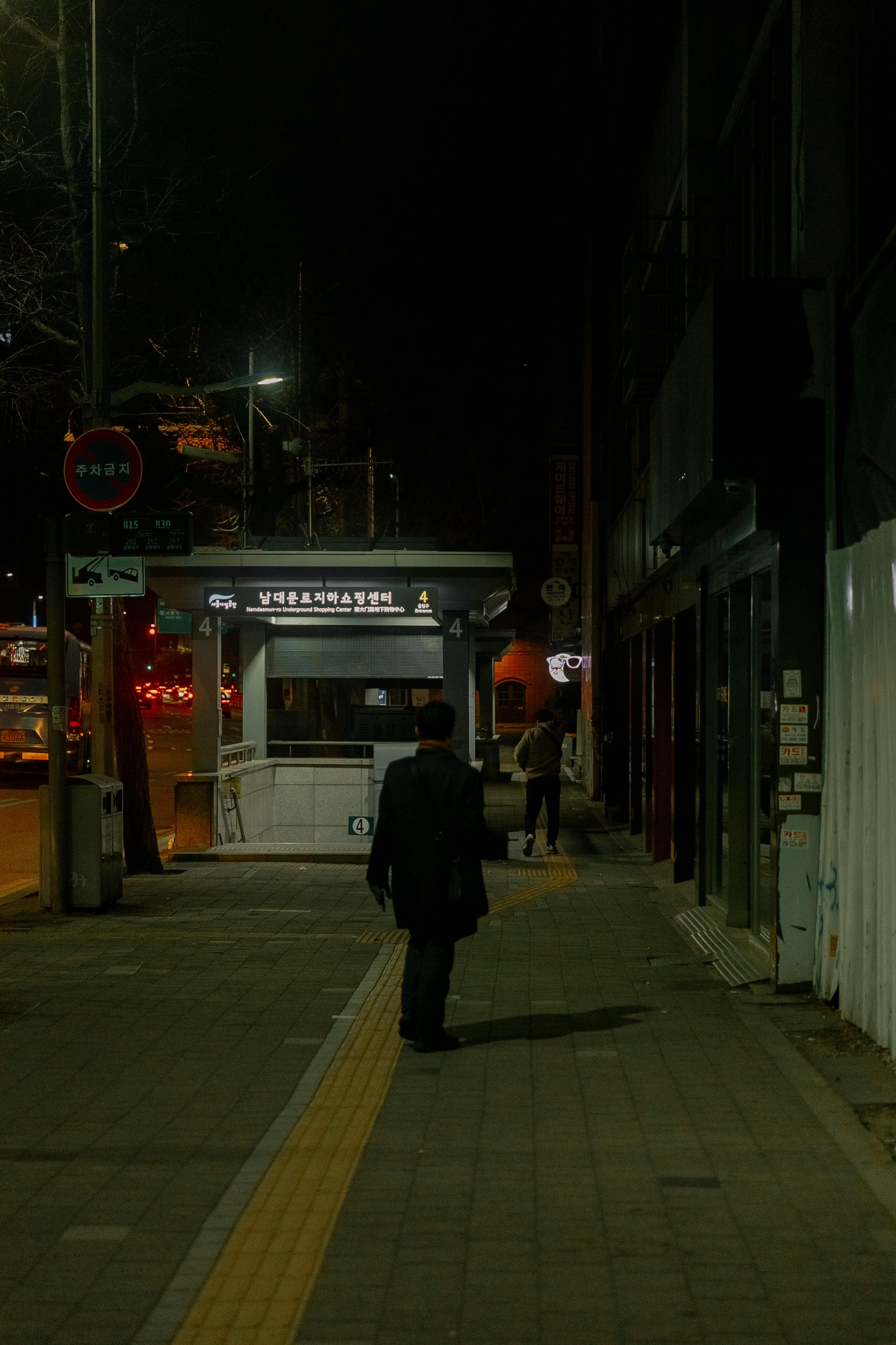 Person Walking on Sidewalk at Night · Free Stock Photo