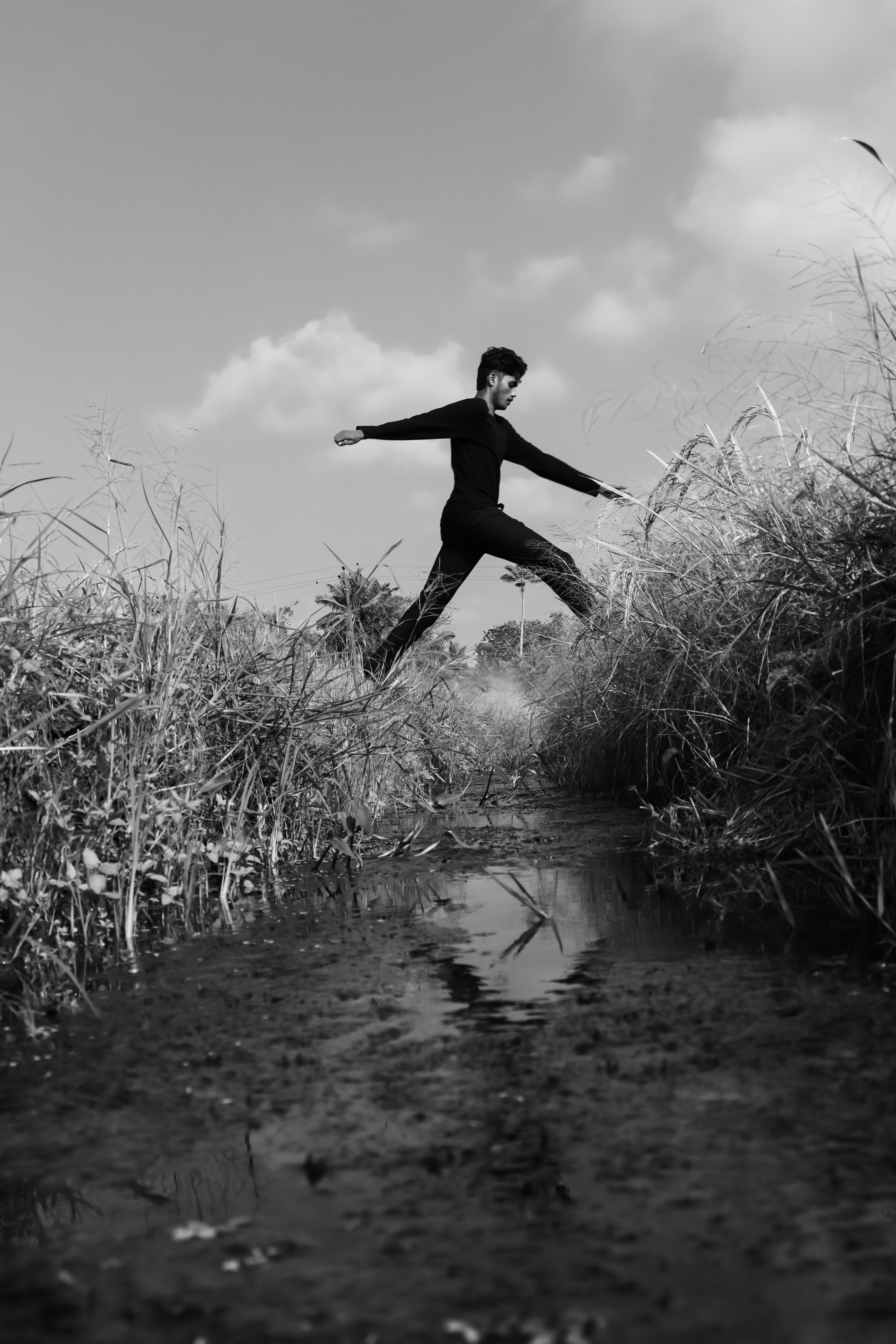 Man Jumping over Canal on Field · Free Stock Photo