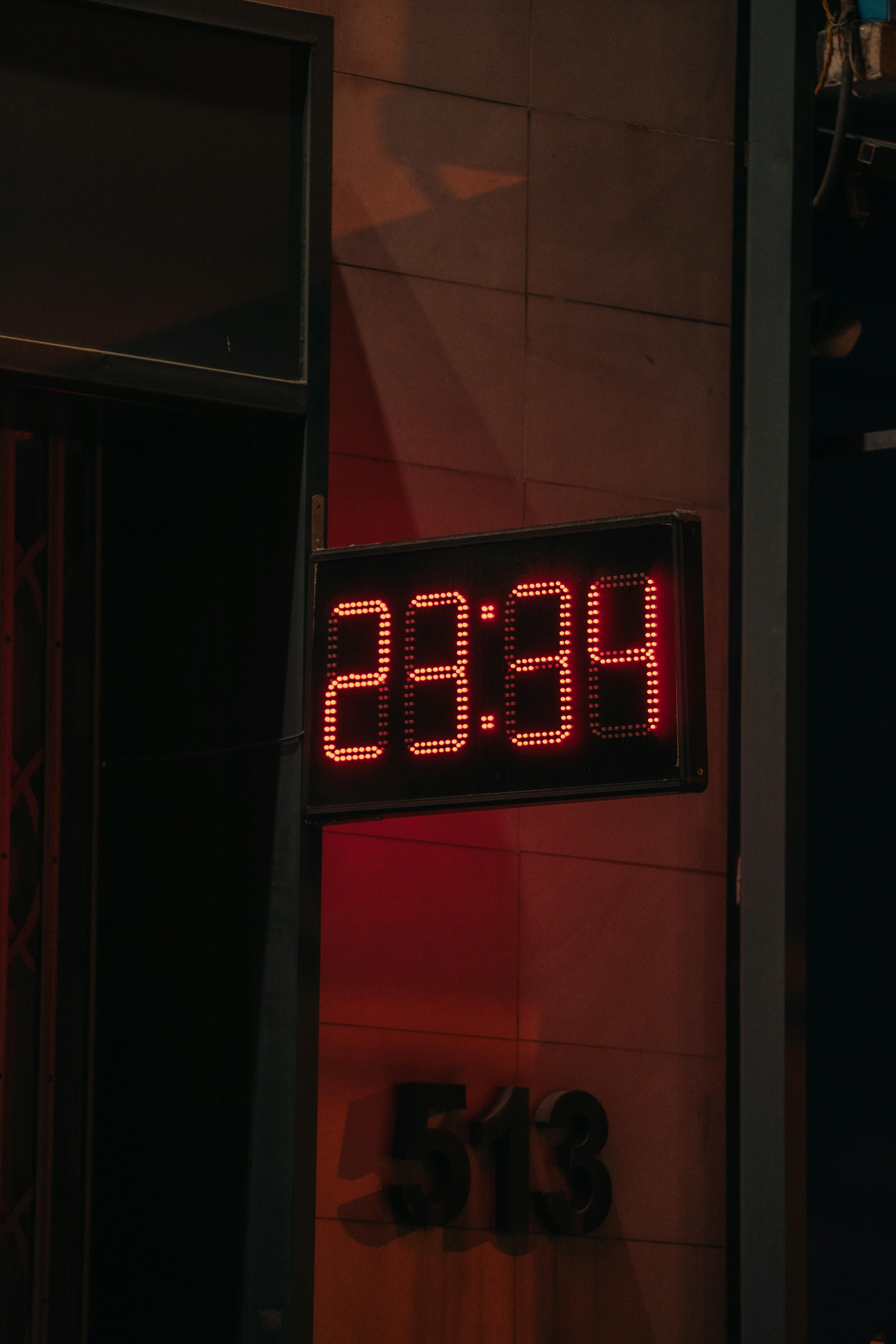 A red digital clock on a building · Free Stock Photo