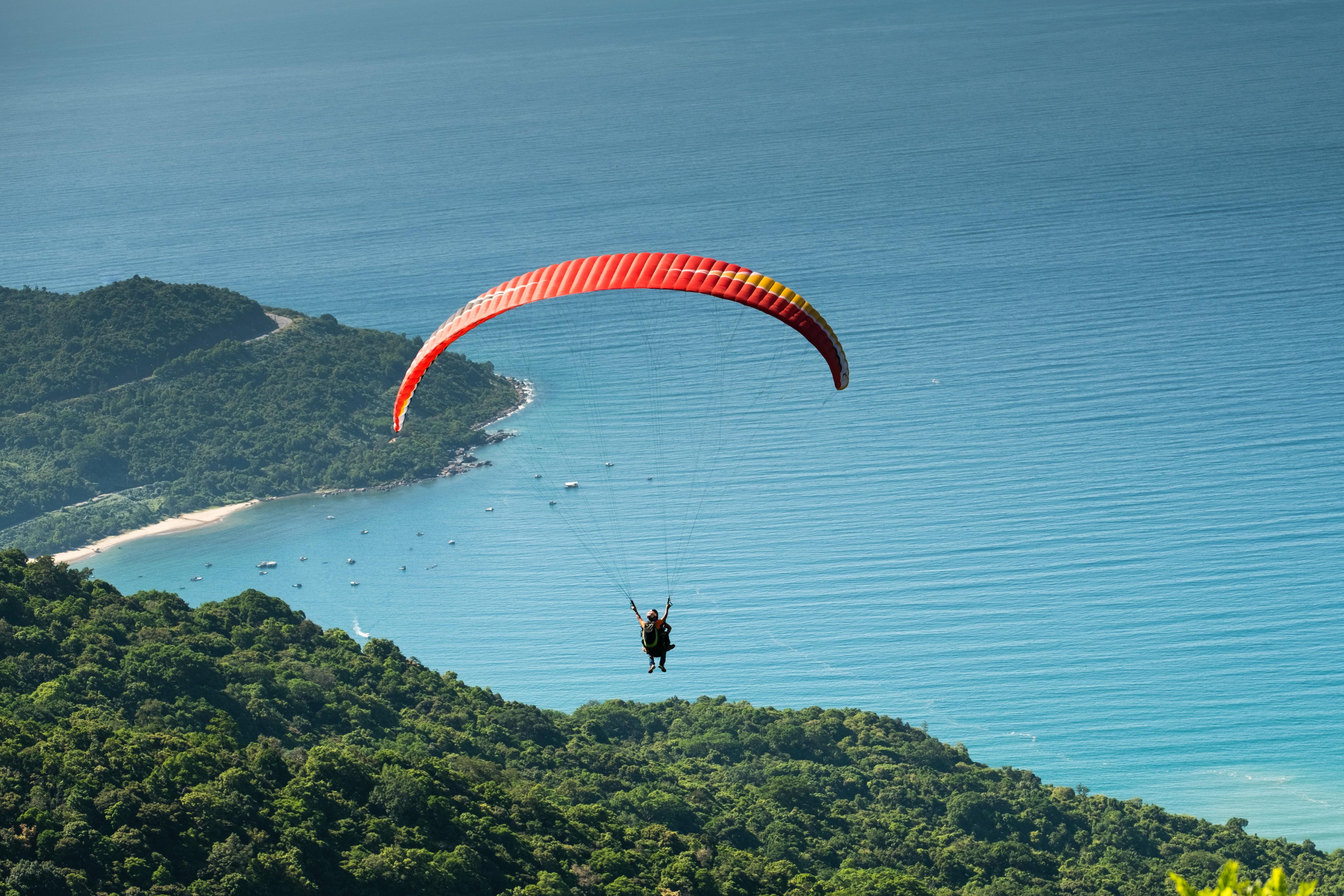 Photo of Person Paragliding Over Forest · Free Stock Photo