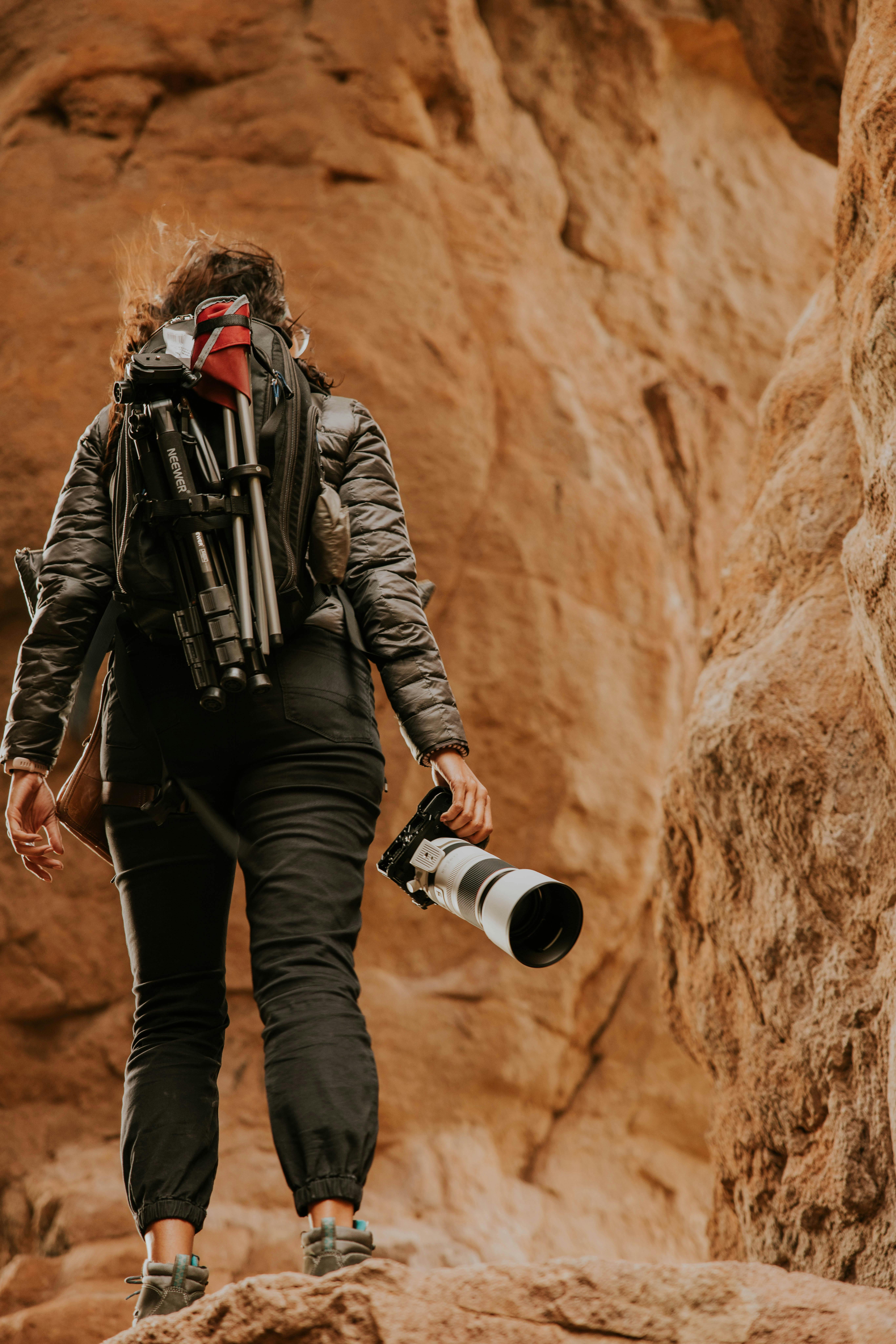 Back of a Female Photographer Standing in a Cave · Free Stock Photo