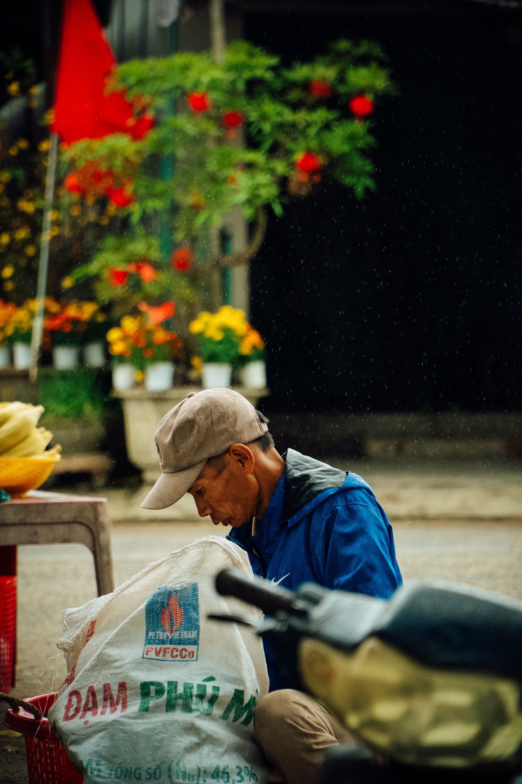 Man Vendor in Baseball Hat Sitting at Market Stall · Free Stock Photo