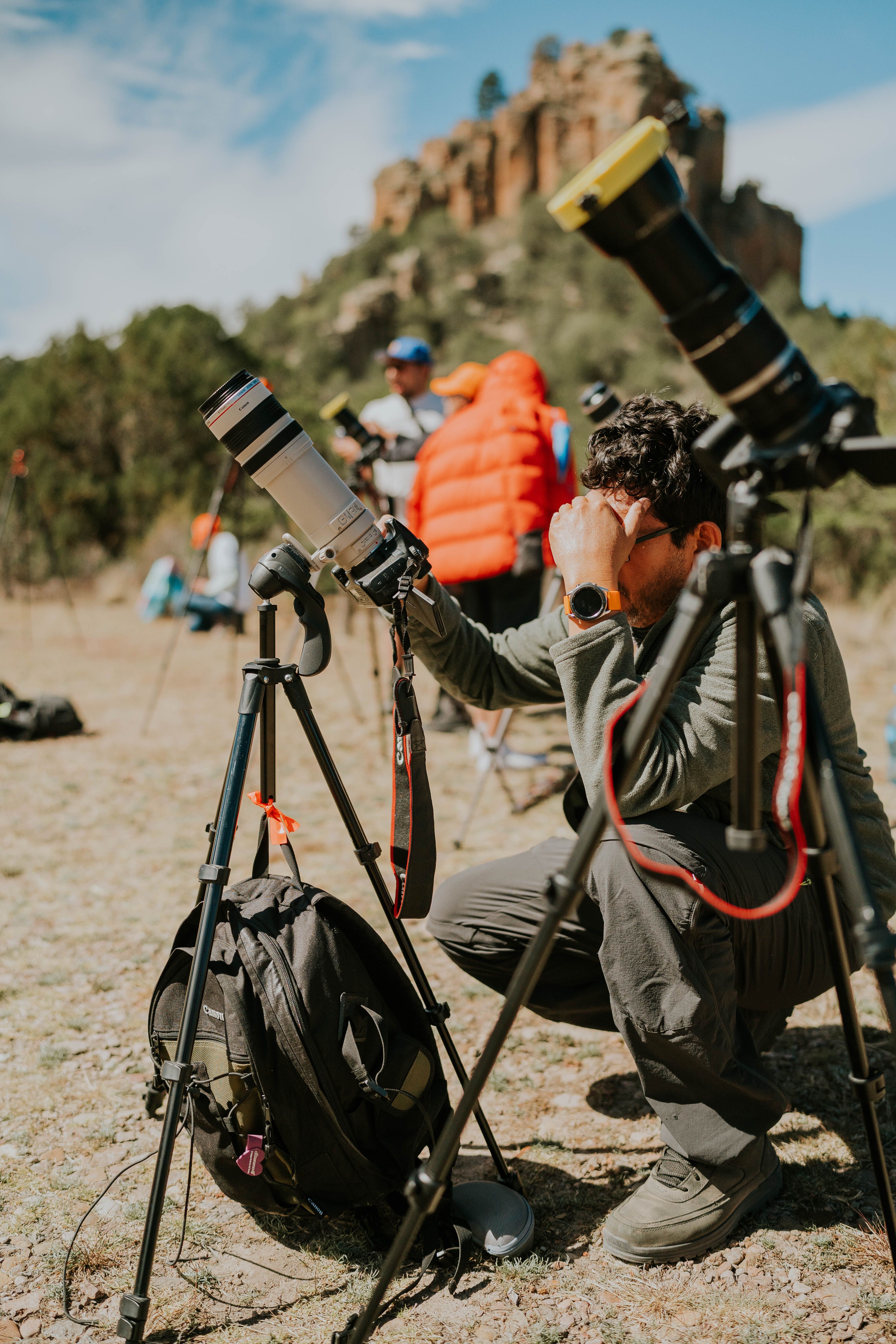 A man with a camera and tripod on the ground · Free Stock Photo