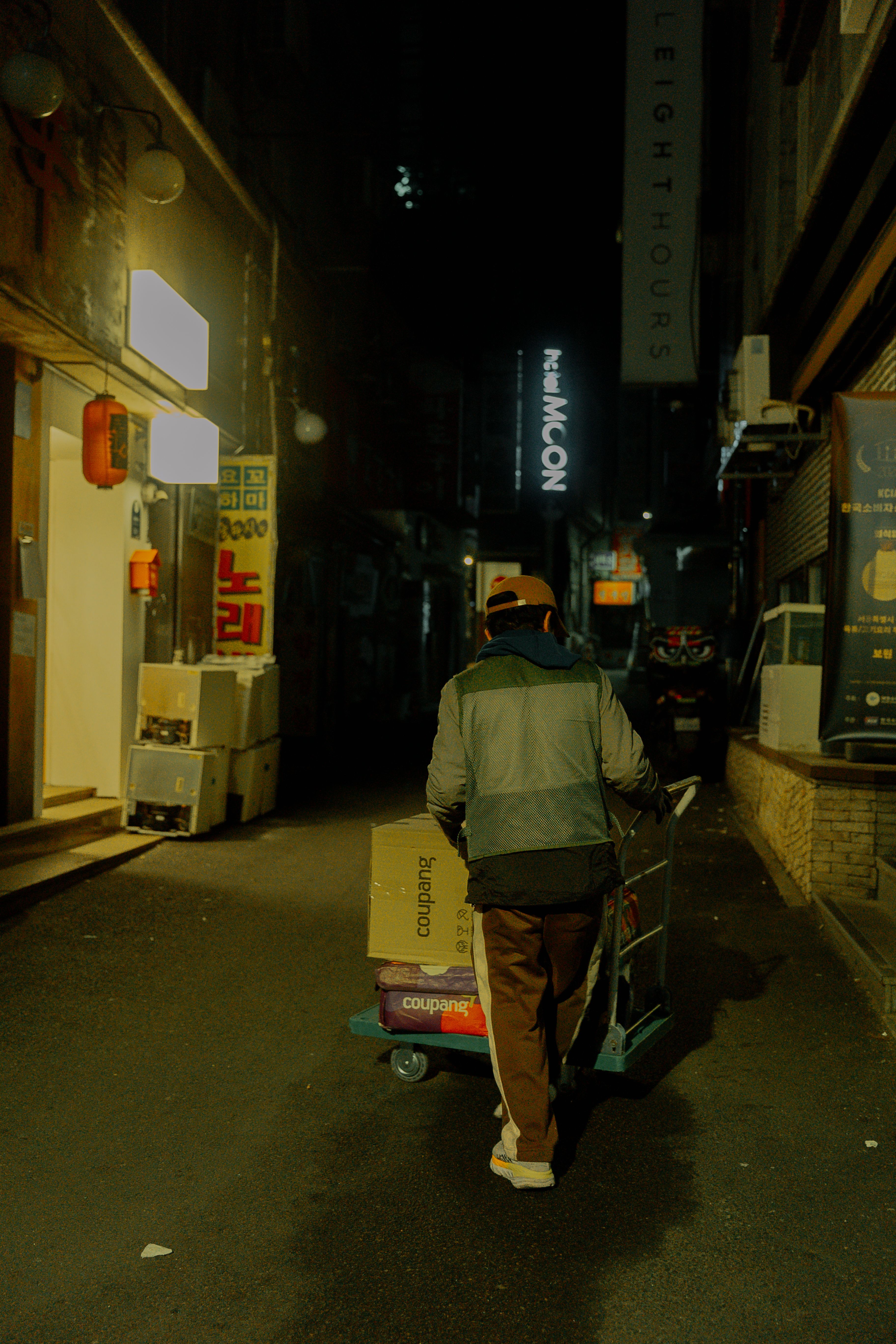 Man Walking with Packages on Trolley at Night · Free Stock Photo