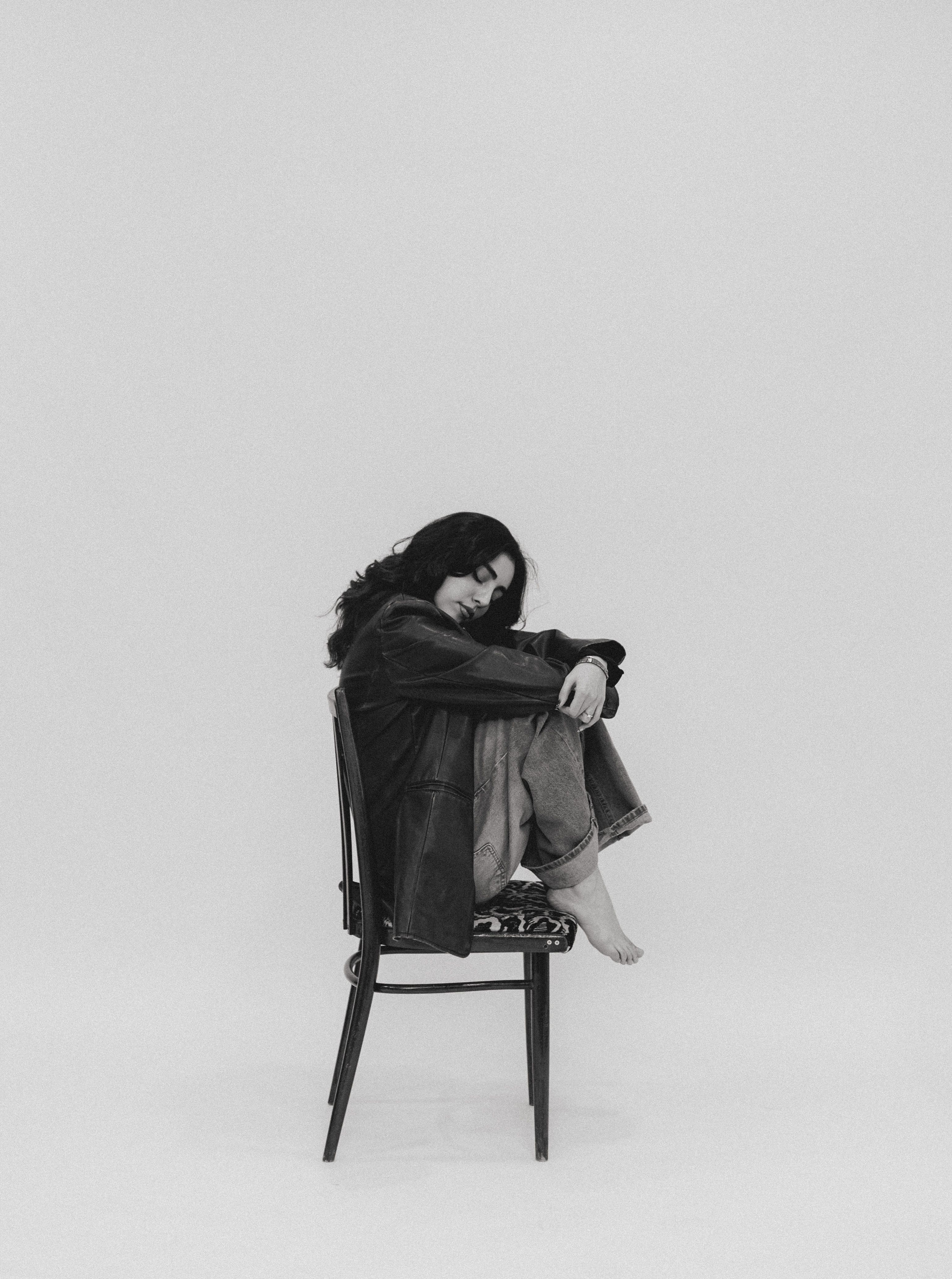 Black and White Photo of a Woman Sitting on a Chair · Free Stock Photo