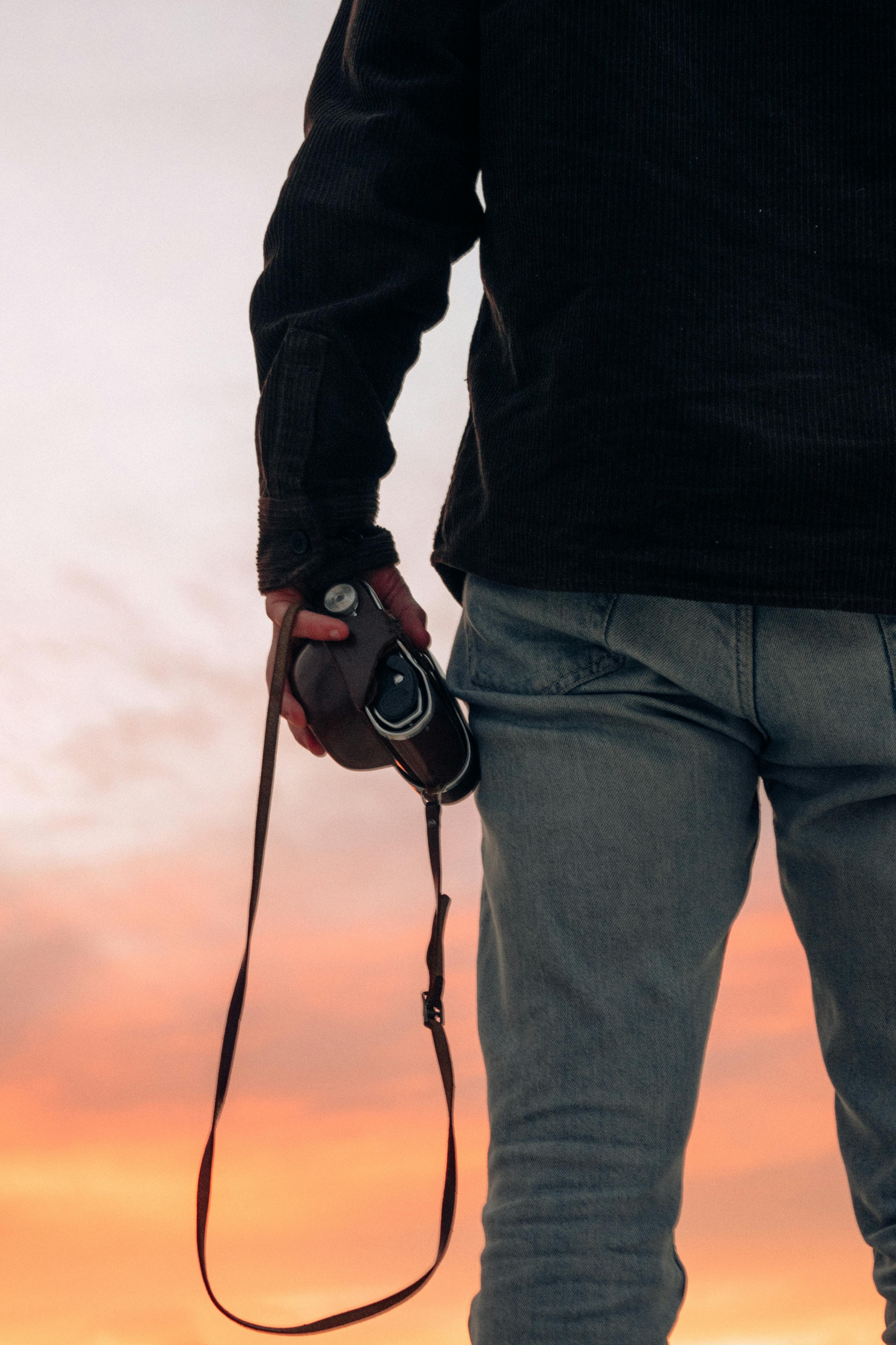 Man Standing and Holding Camera · Free Stock Photo