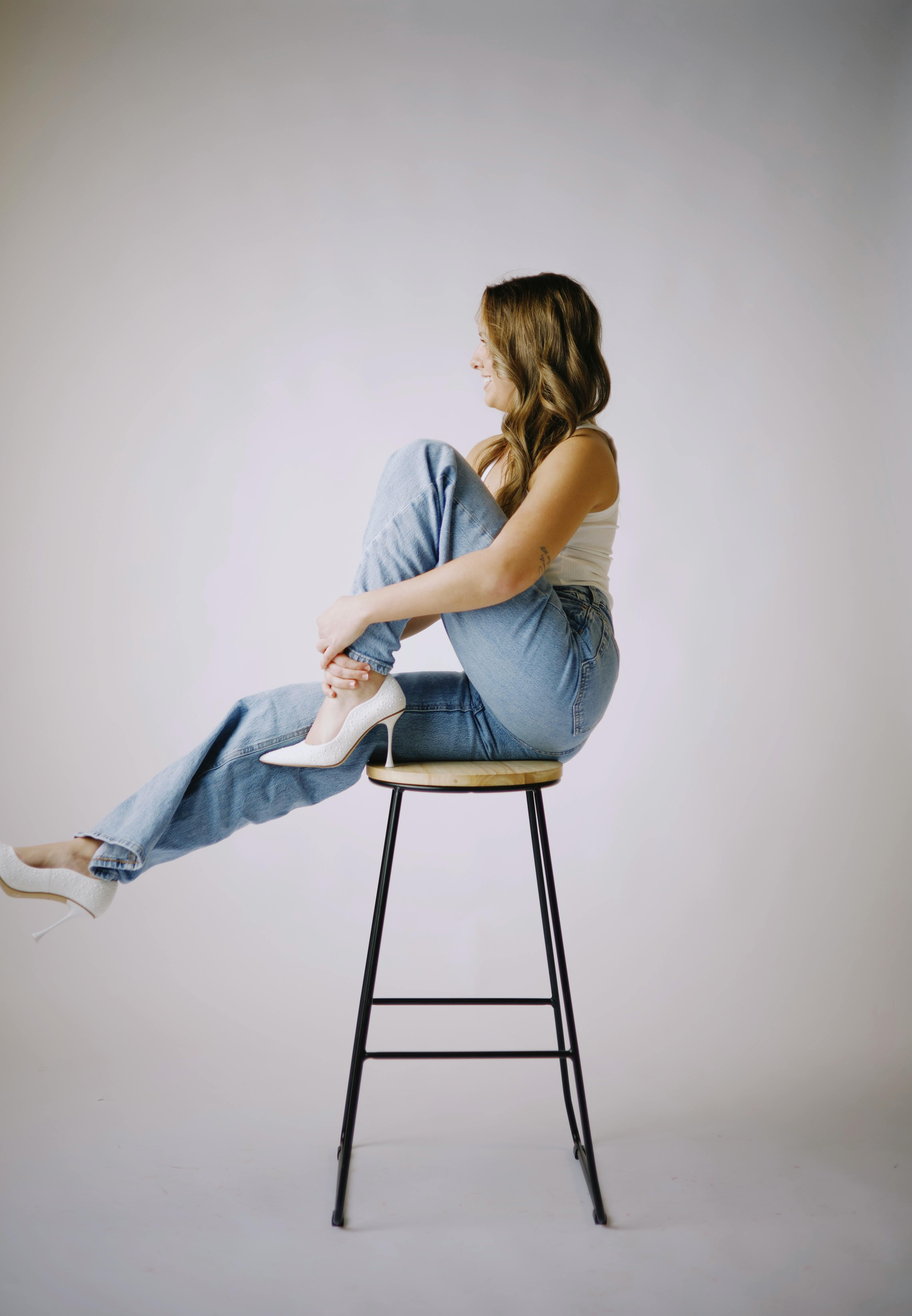 Woman in Jeans Sitting on Chair · Free Stock Photo