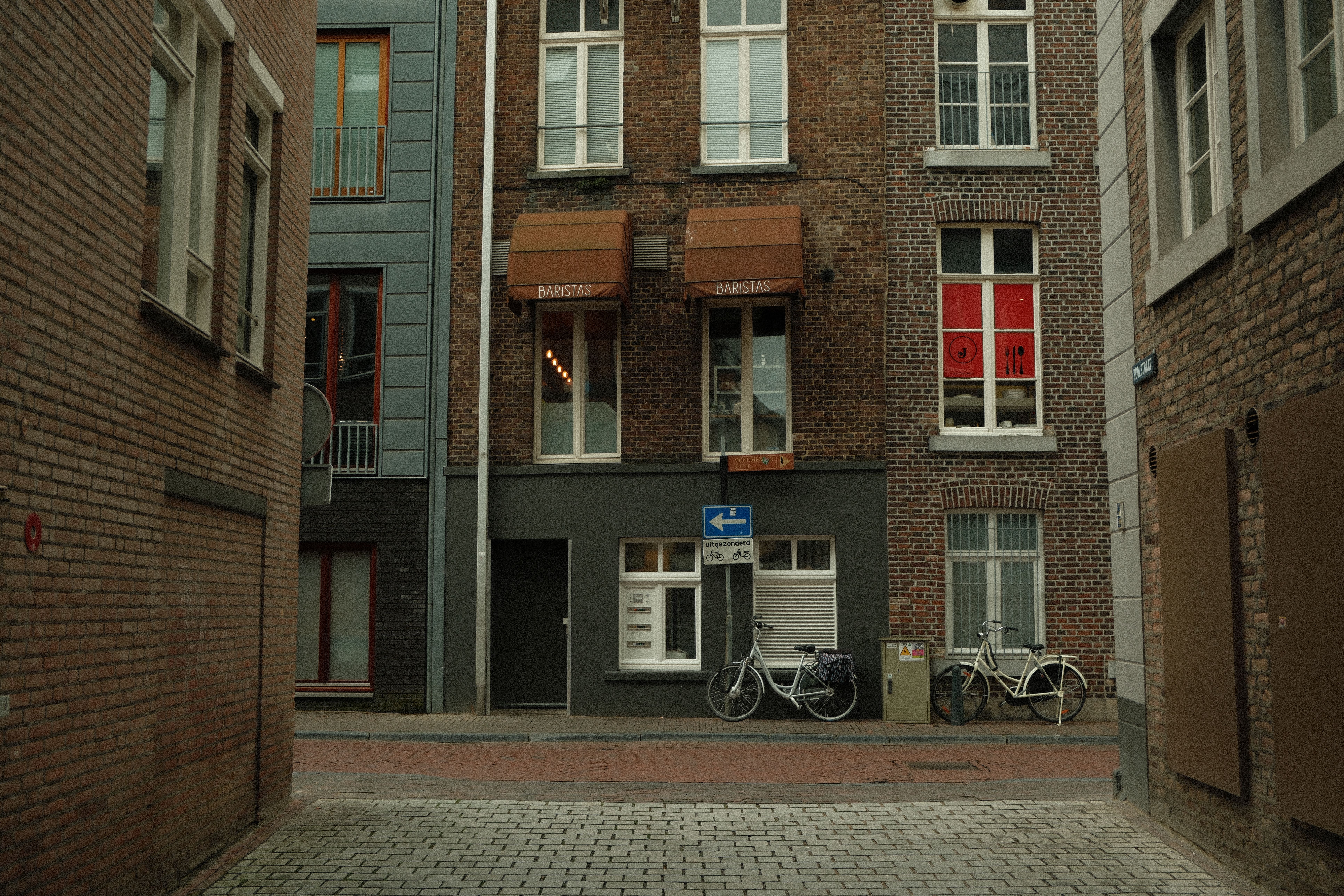 A brick building with windows and a bike parked outside · Free Stock Photo