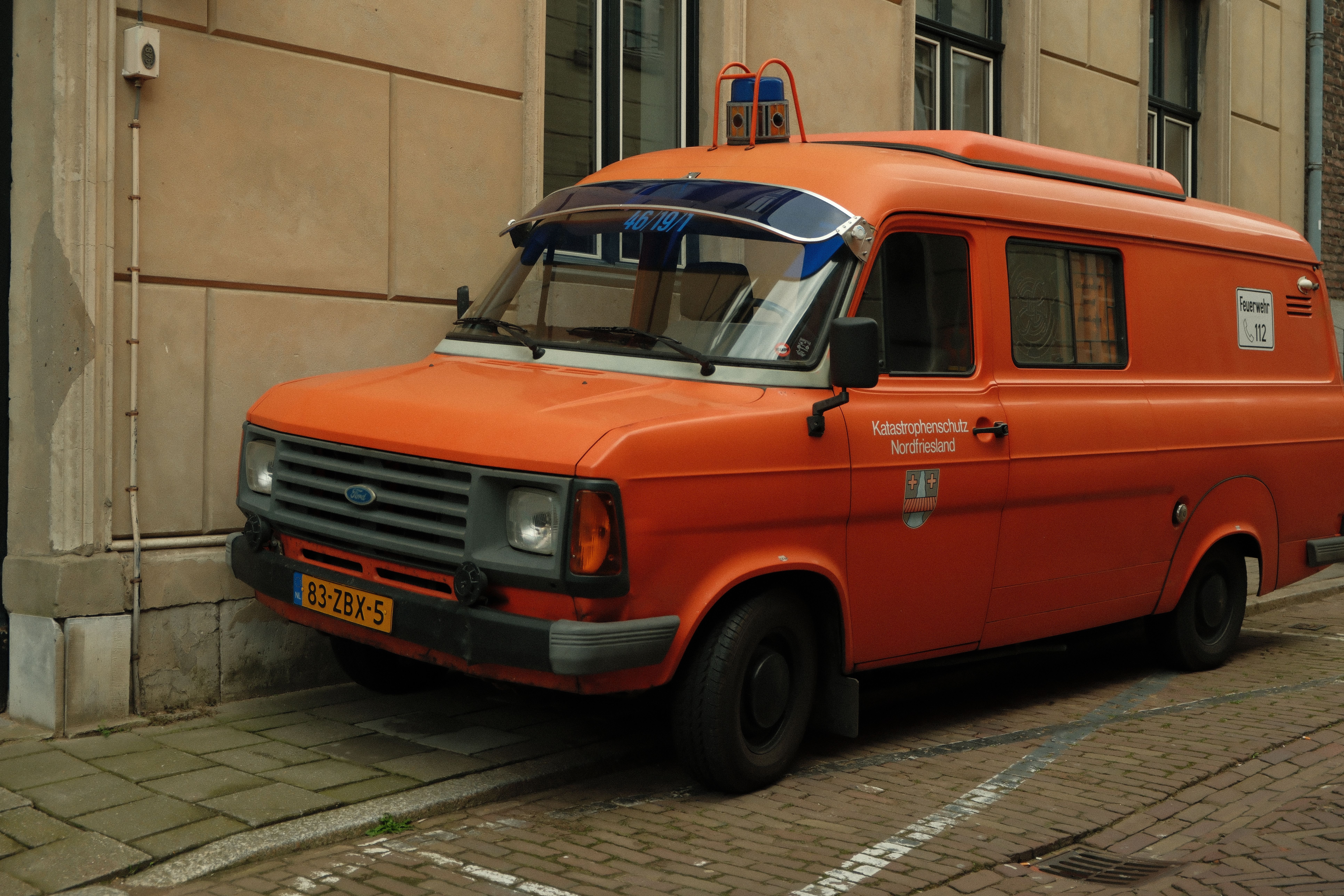 An orange van parked on the side of a street · Free Stock Photo