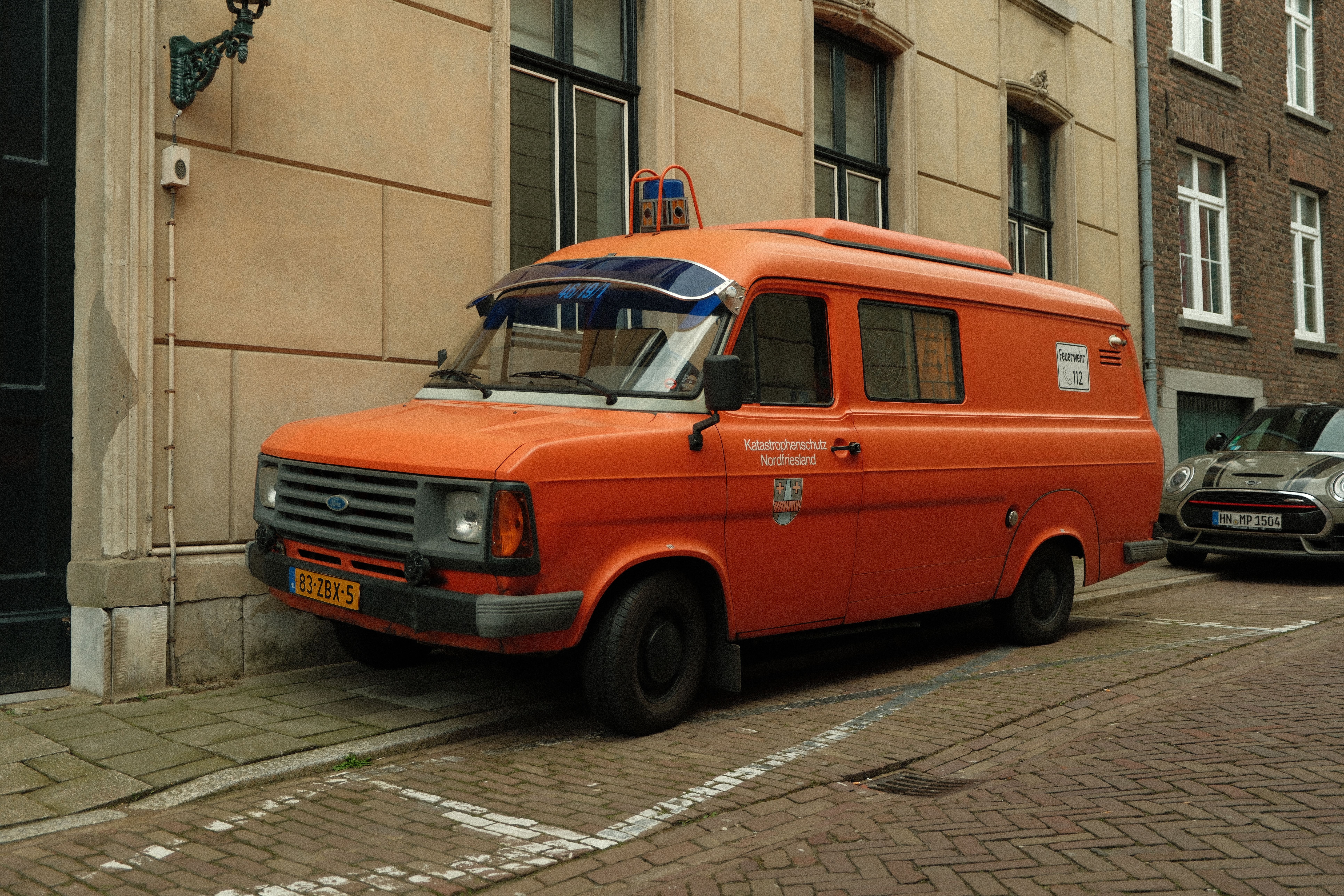 An orange van parked on the side of a street · Free Stock Photo