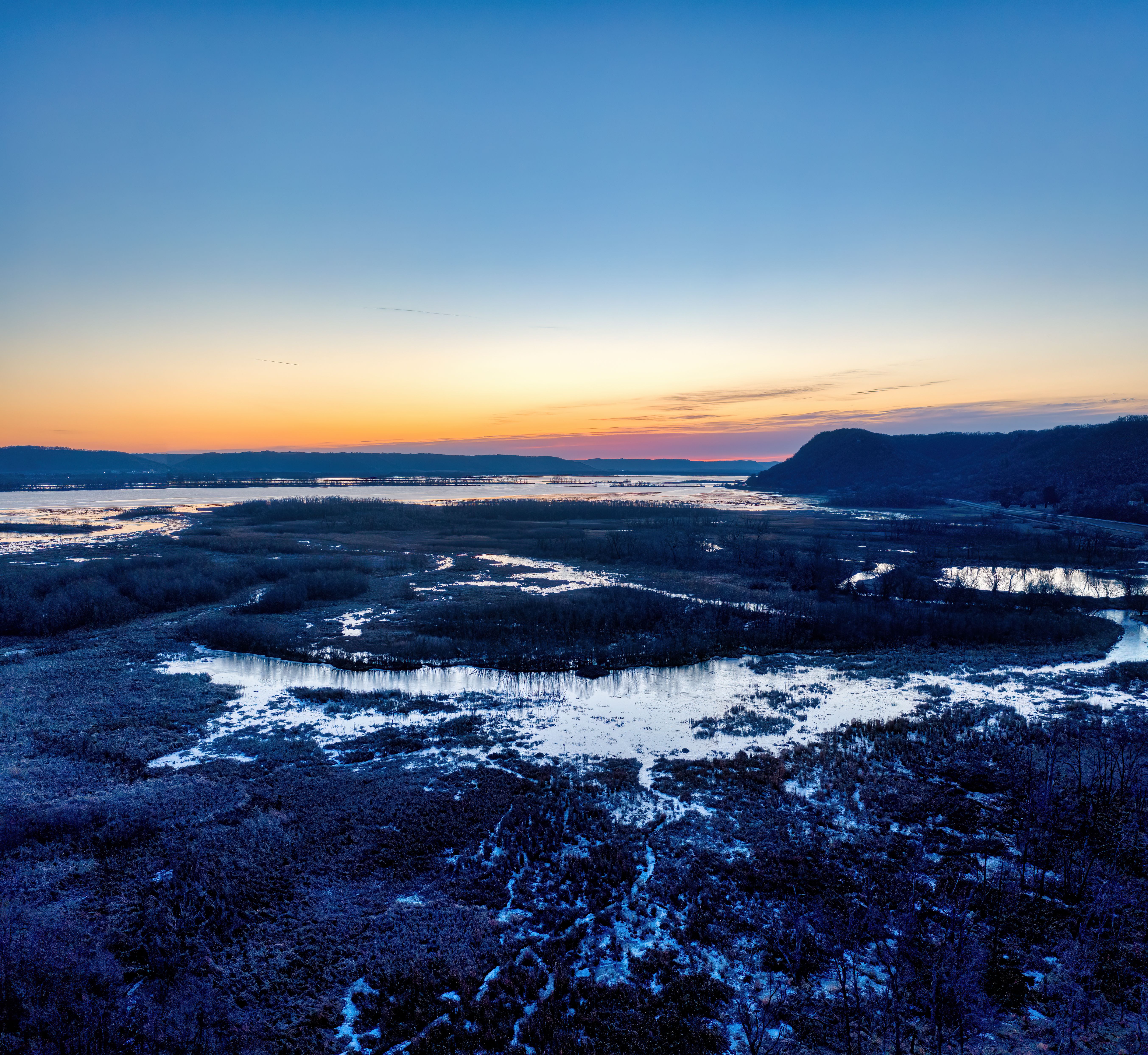 A sunset over a marsh and lake · Free Stock Photo