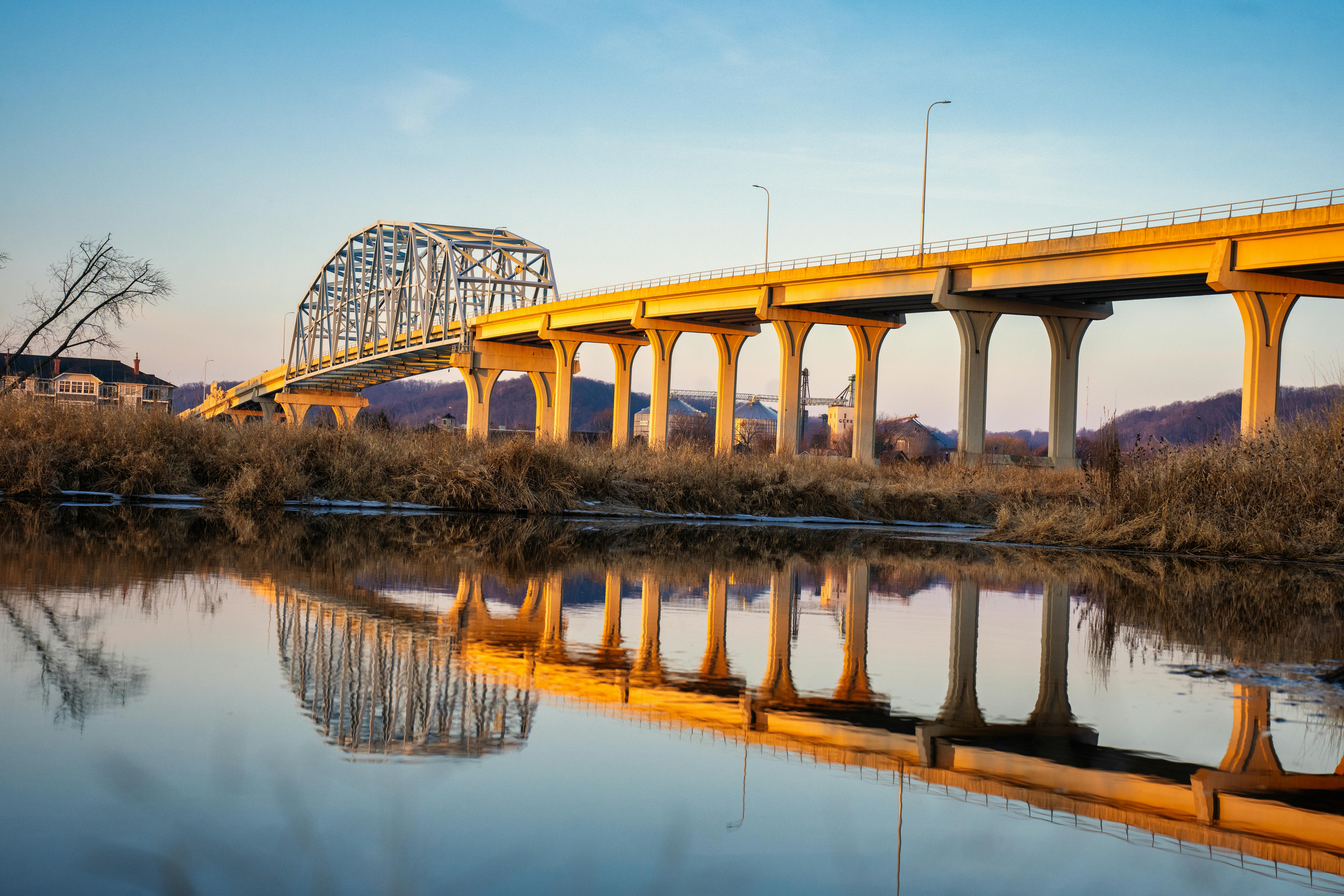 A bridge over water with a reflection of the sky · Free Stock Photo