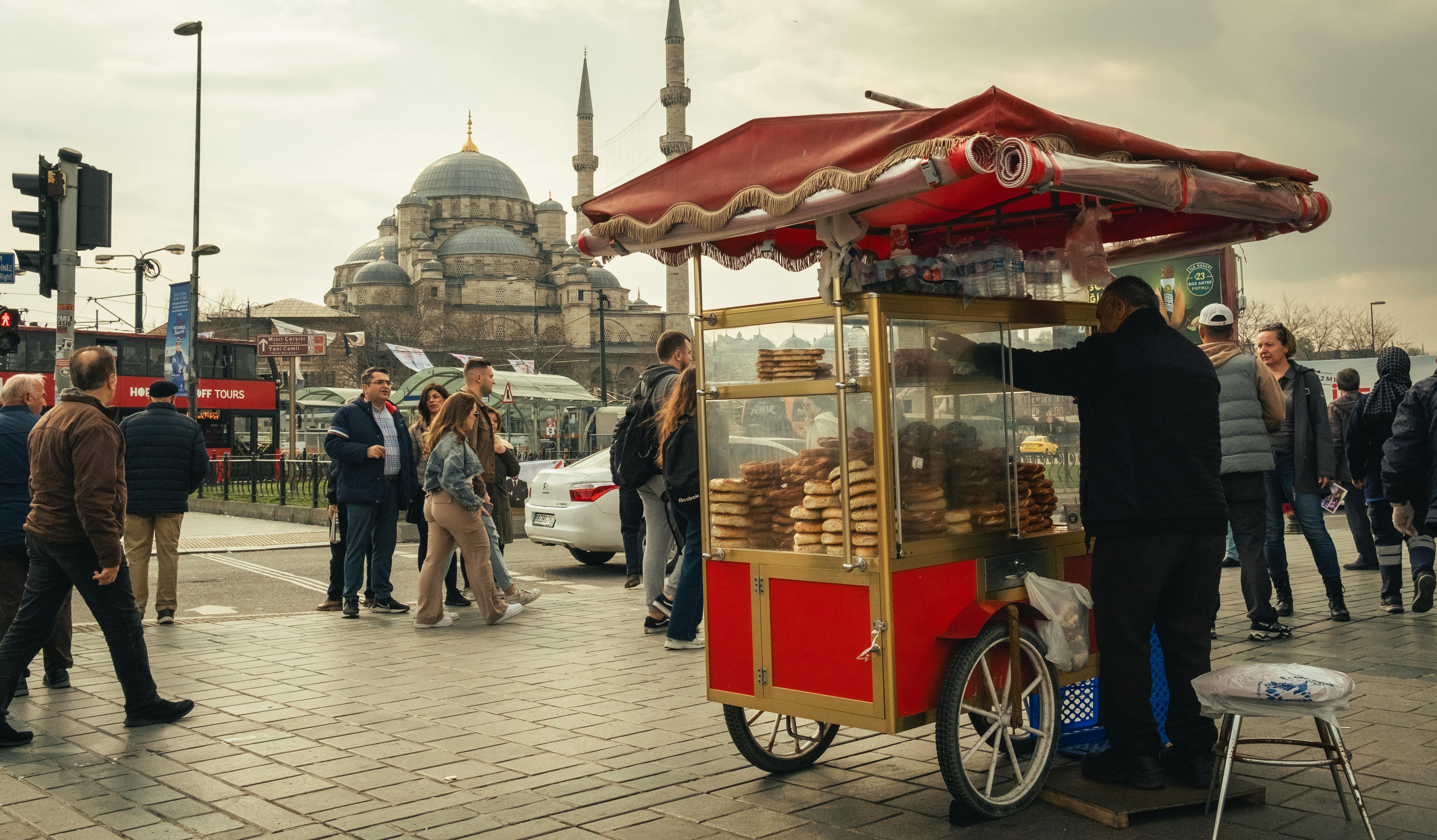A man selling food on a street in front of a mosque · Free Stock Photo