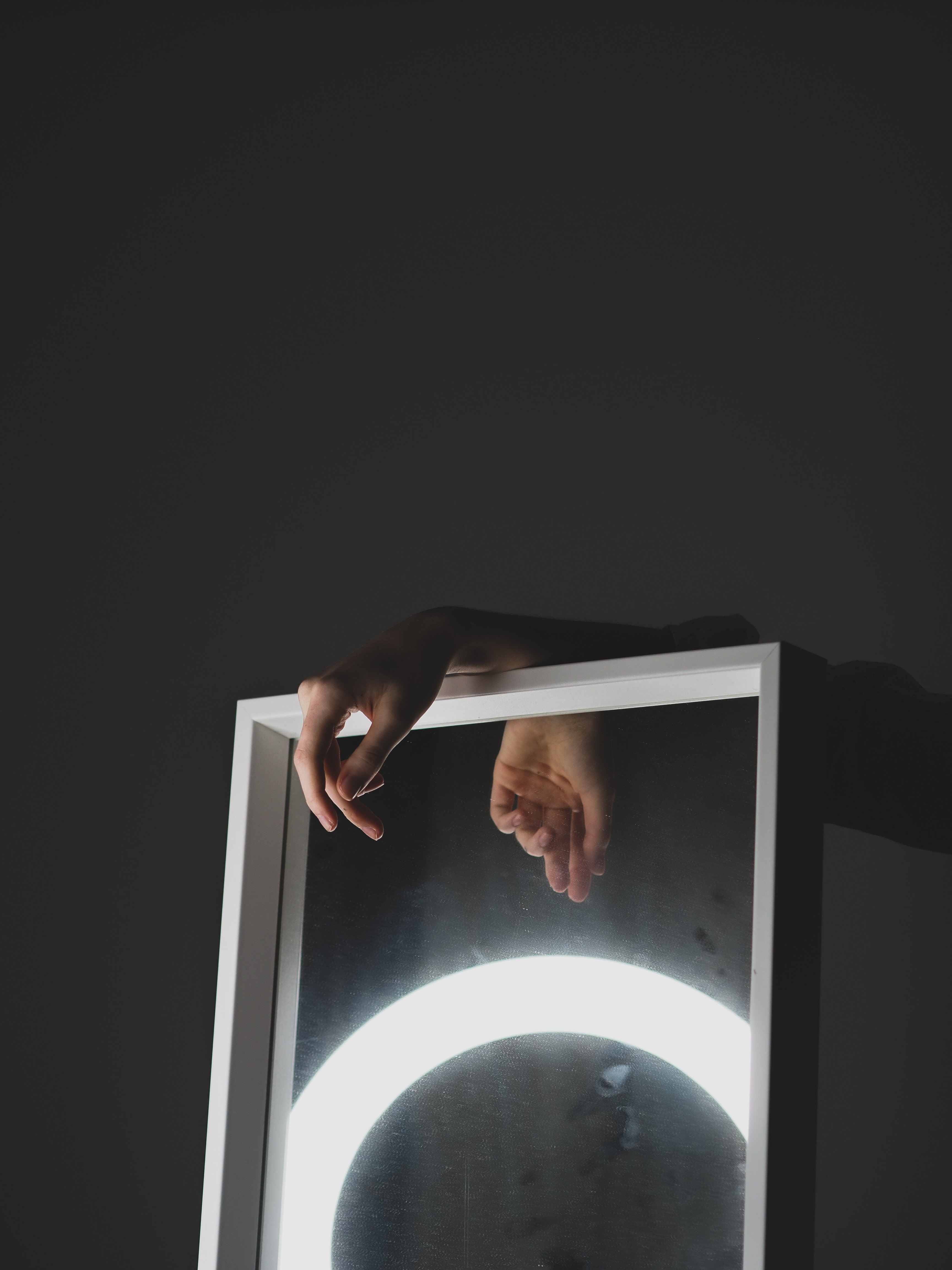 Person Hand over Mirror with Lamp Reflection · Free Stock Photo