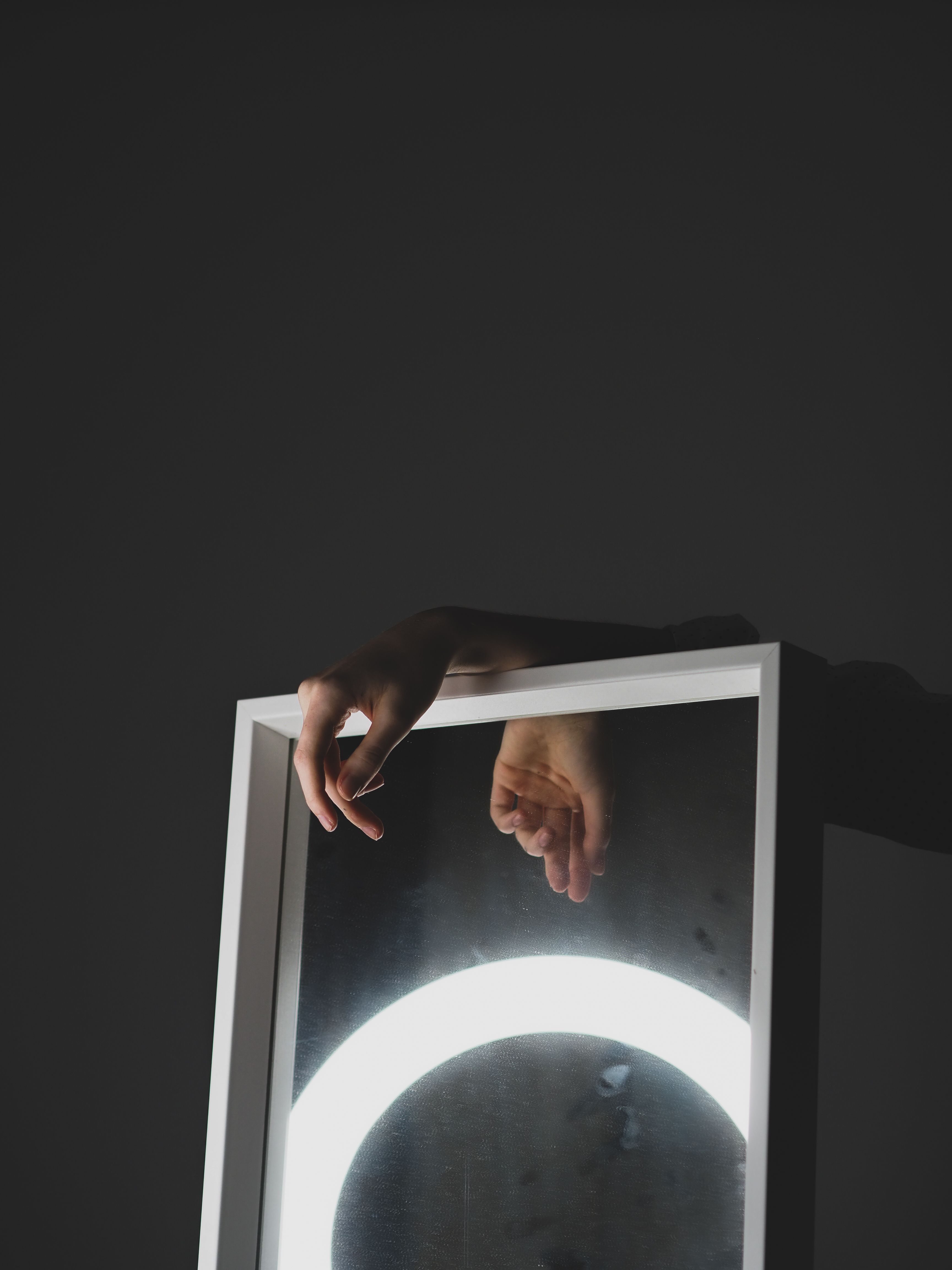 Person Hand over Mirror with Lamp Reflection · Free Stock Photo