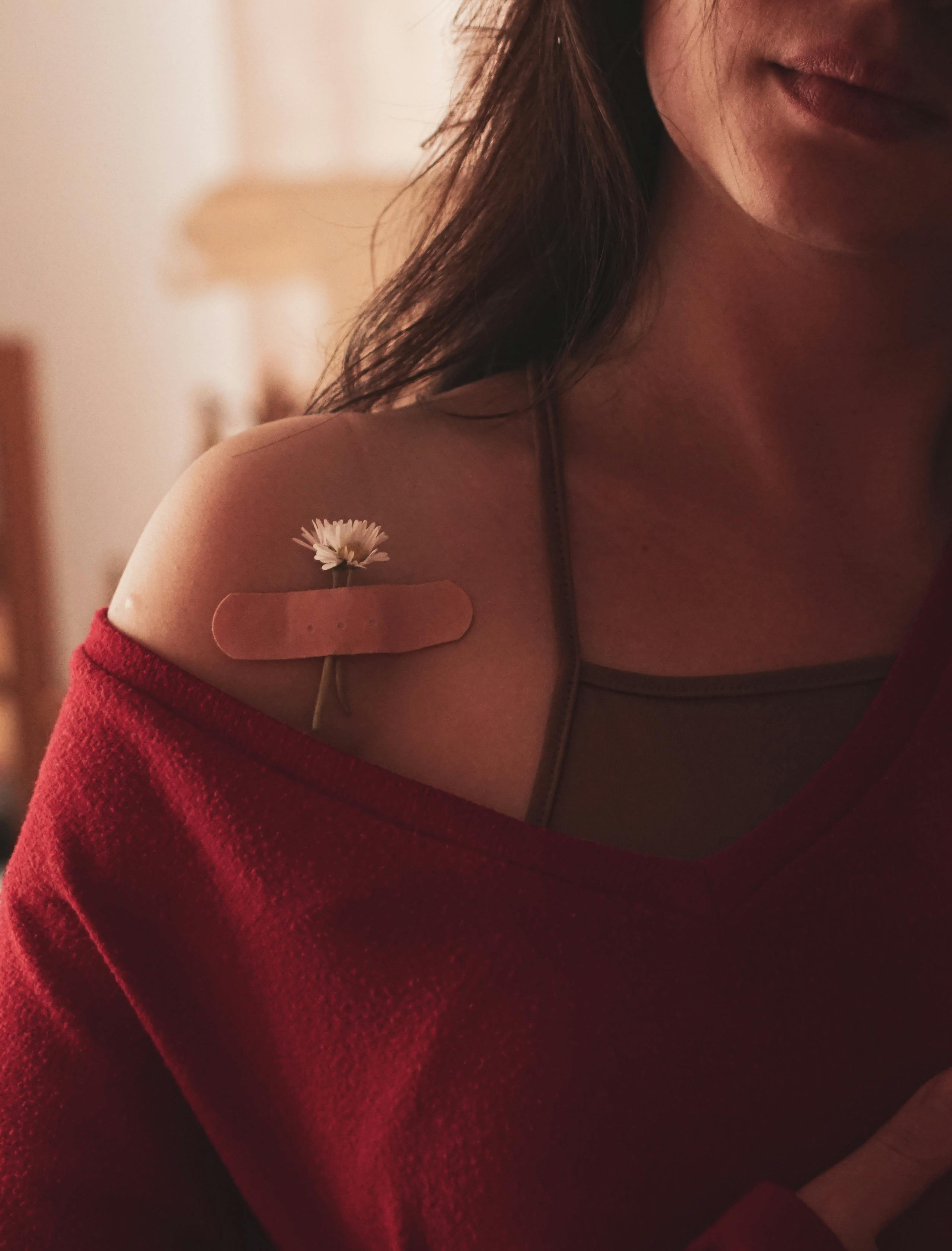 A Woman with a Flower Taped to her Shoulder · Free Stock Photo