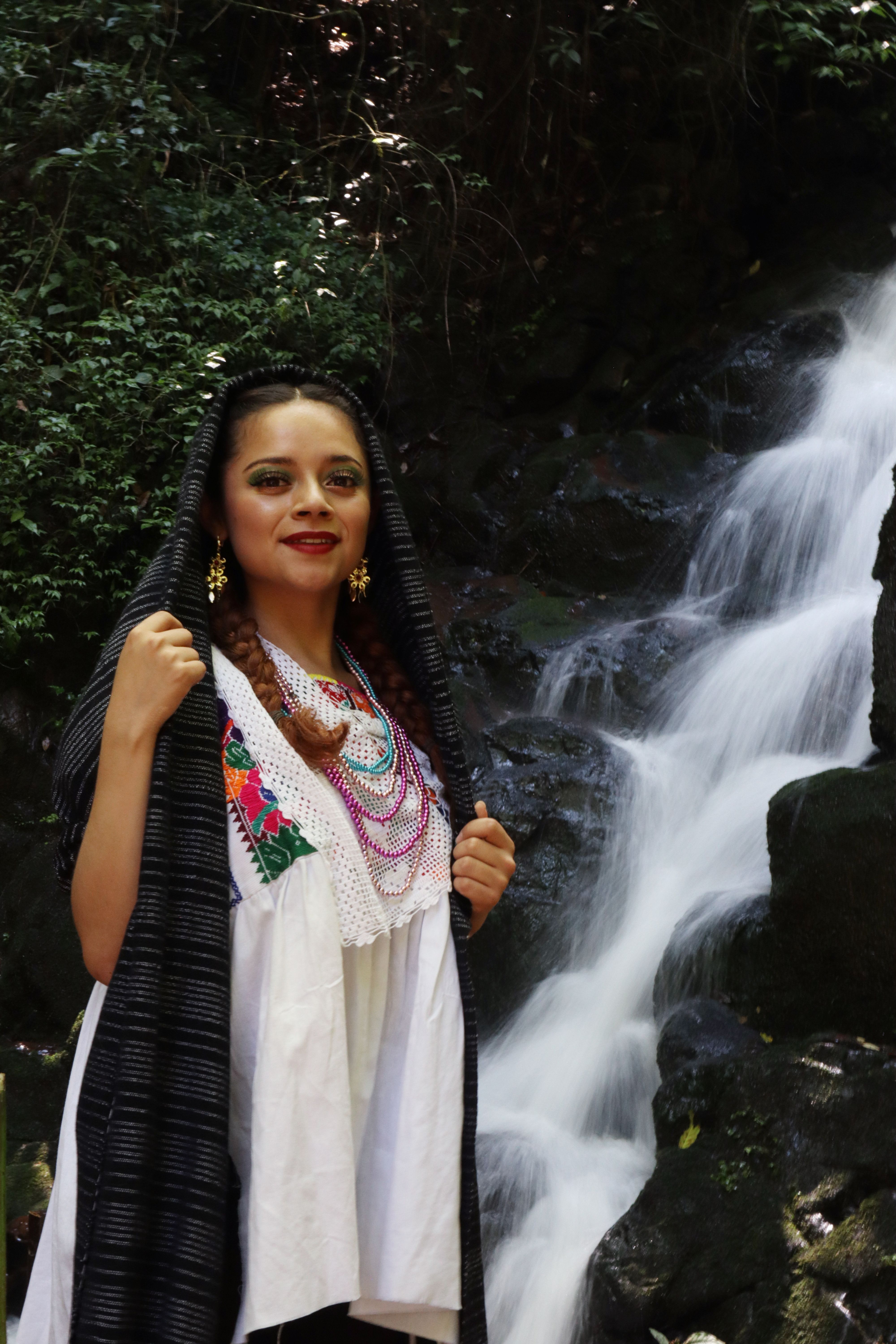 A woman in traditional clothing standing next to a waterfall · Free ...