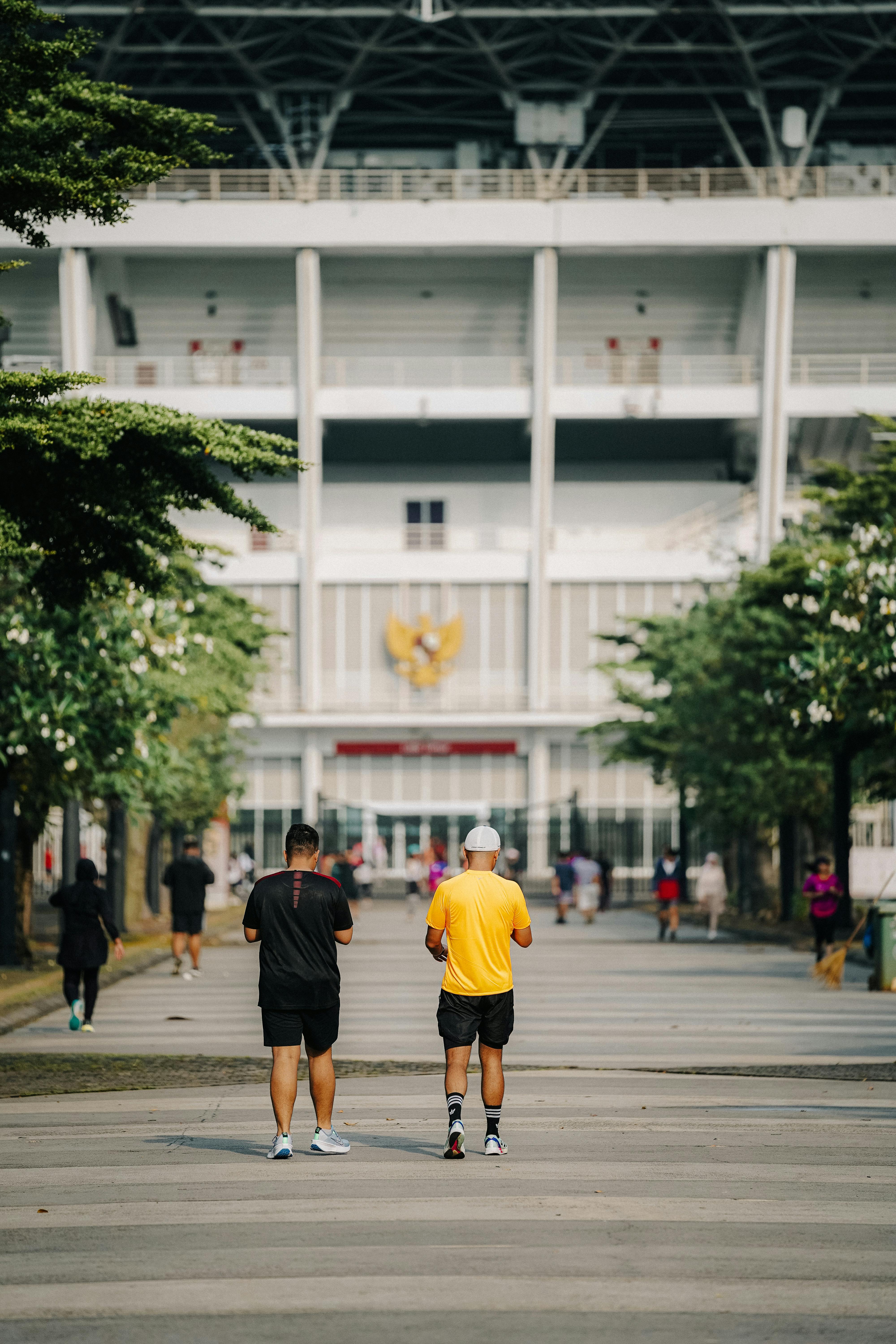 Back View of People Walking to a Stadium · Free Stock Photo