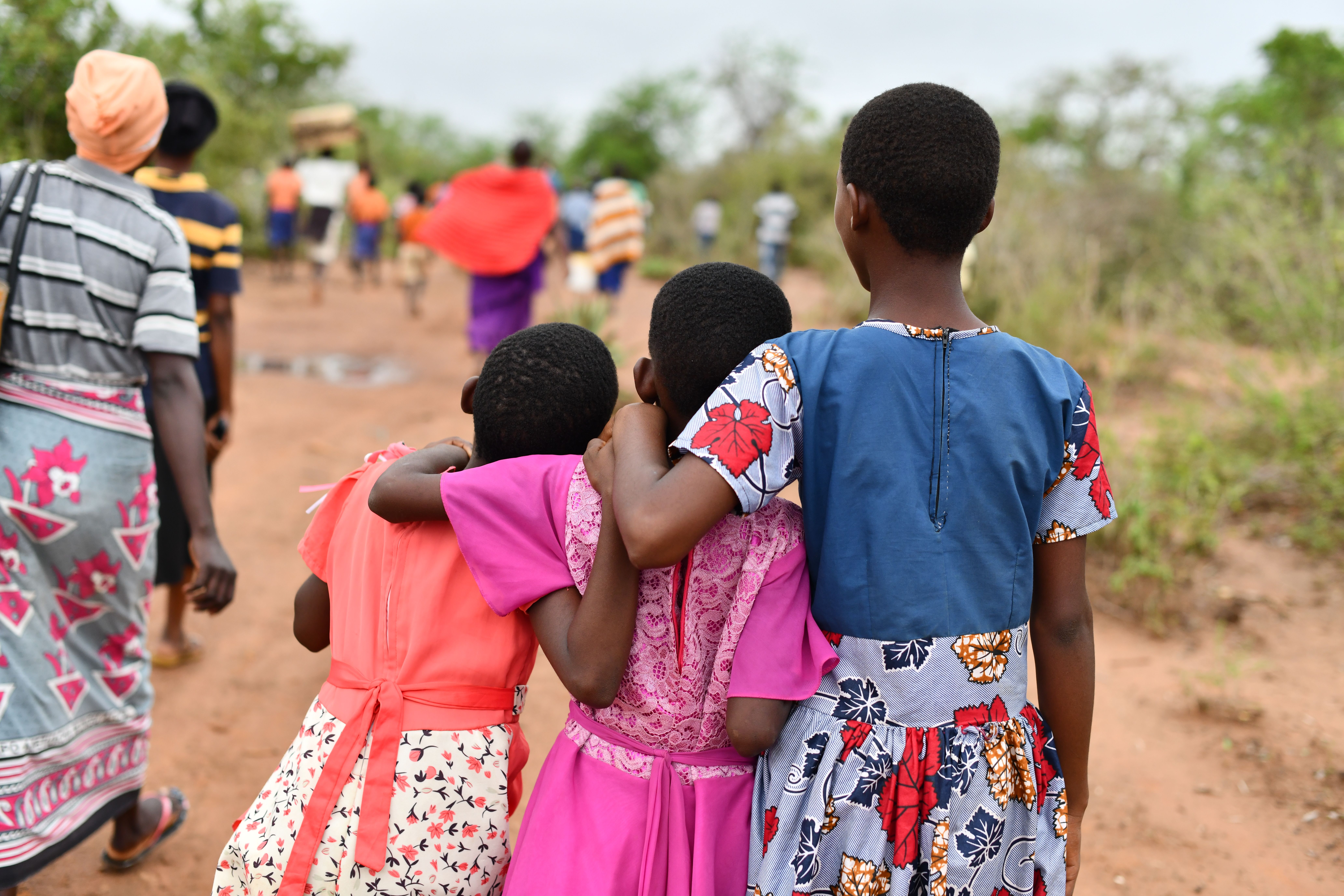 Back View of Kids Hugging on a Dirt Road · Free Stock Photo