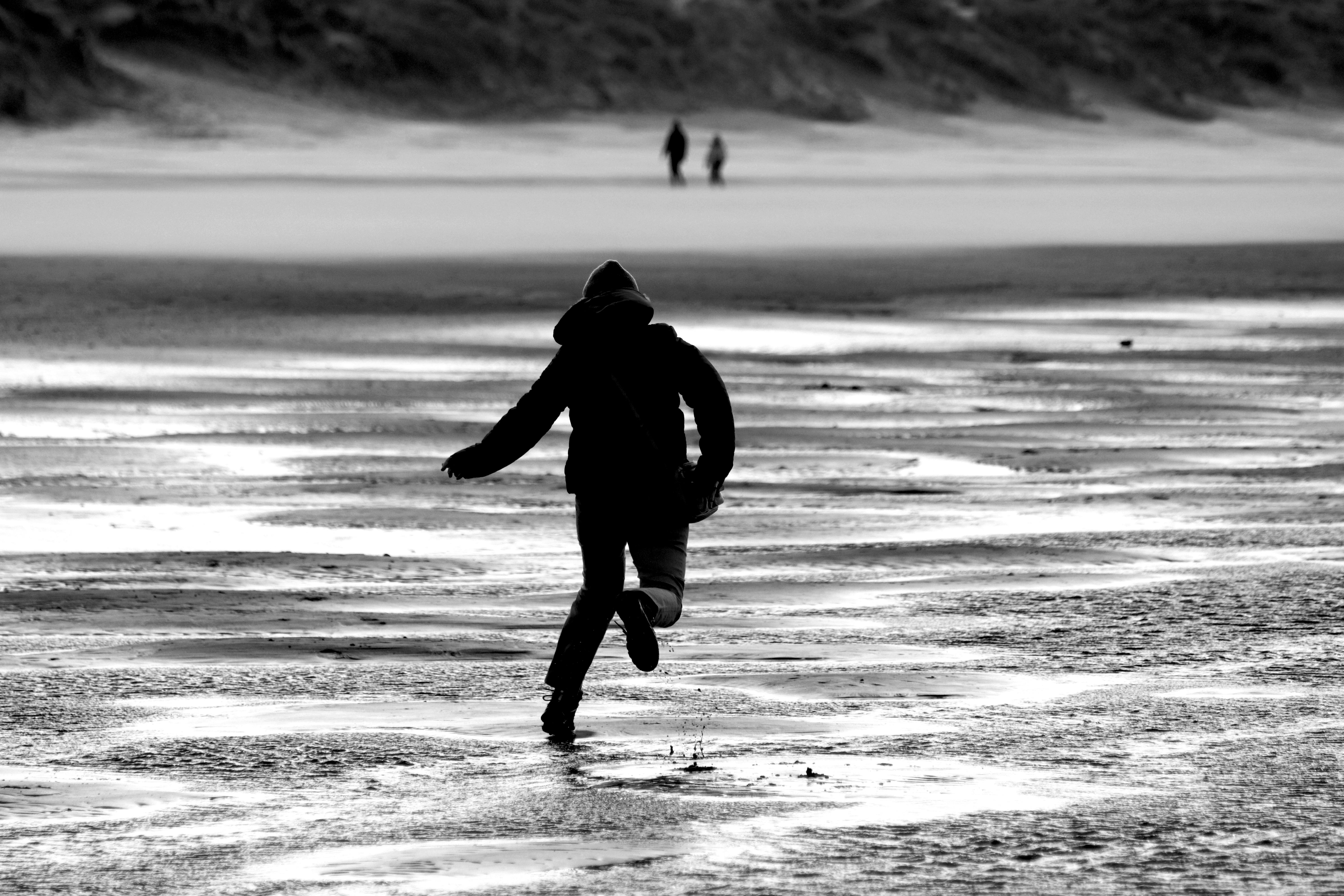 Back View of Person in Jacket Running on Wet Ground · Free Stock Photo
