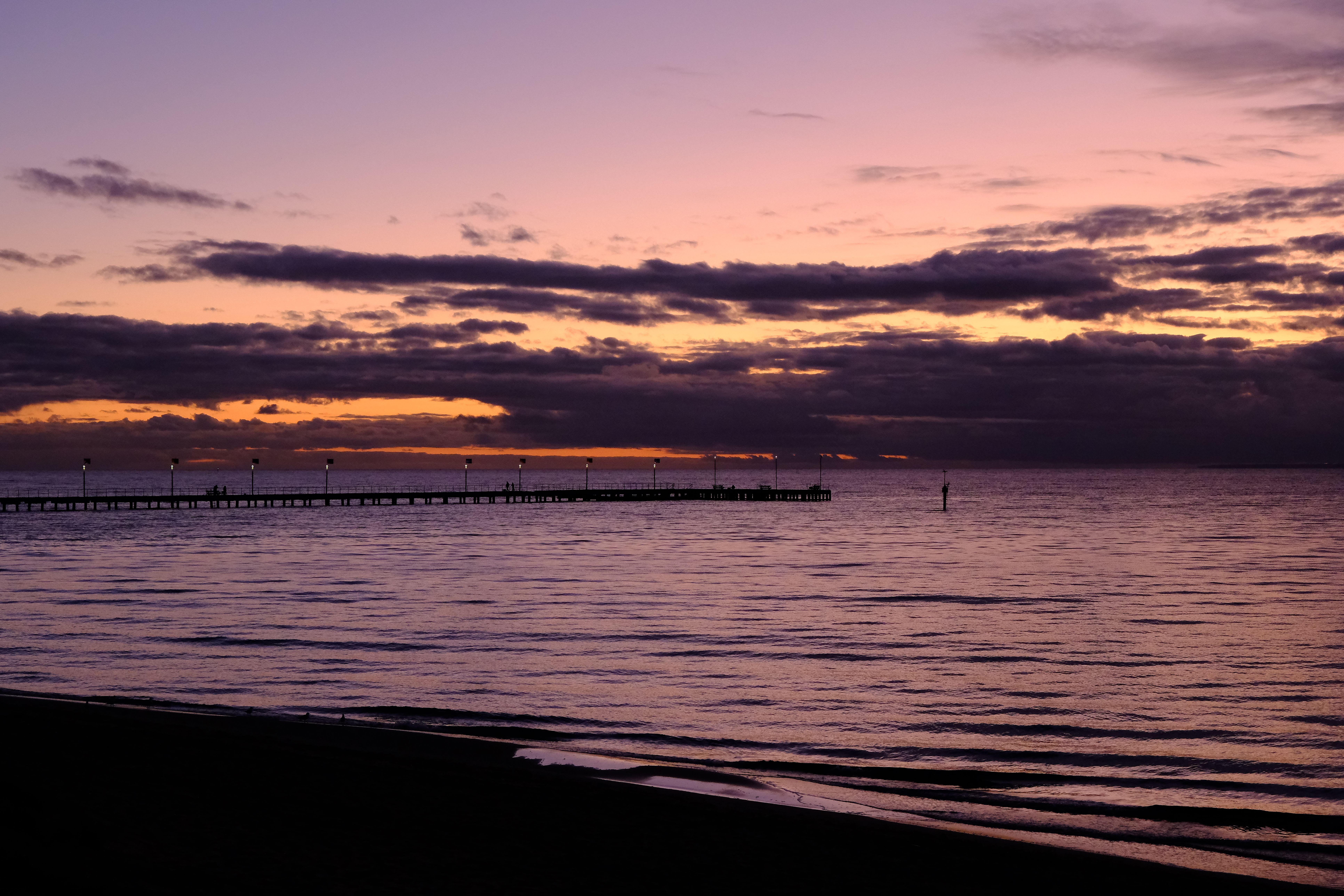 A purple sky with a pier in the distance · Free Stock Photo