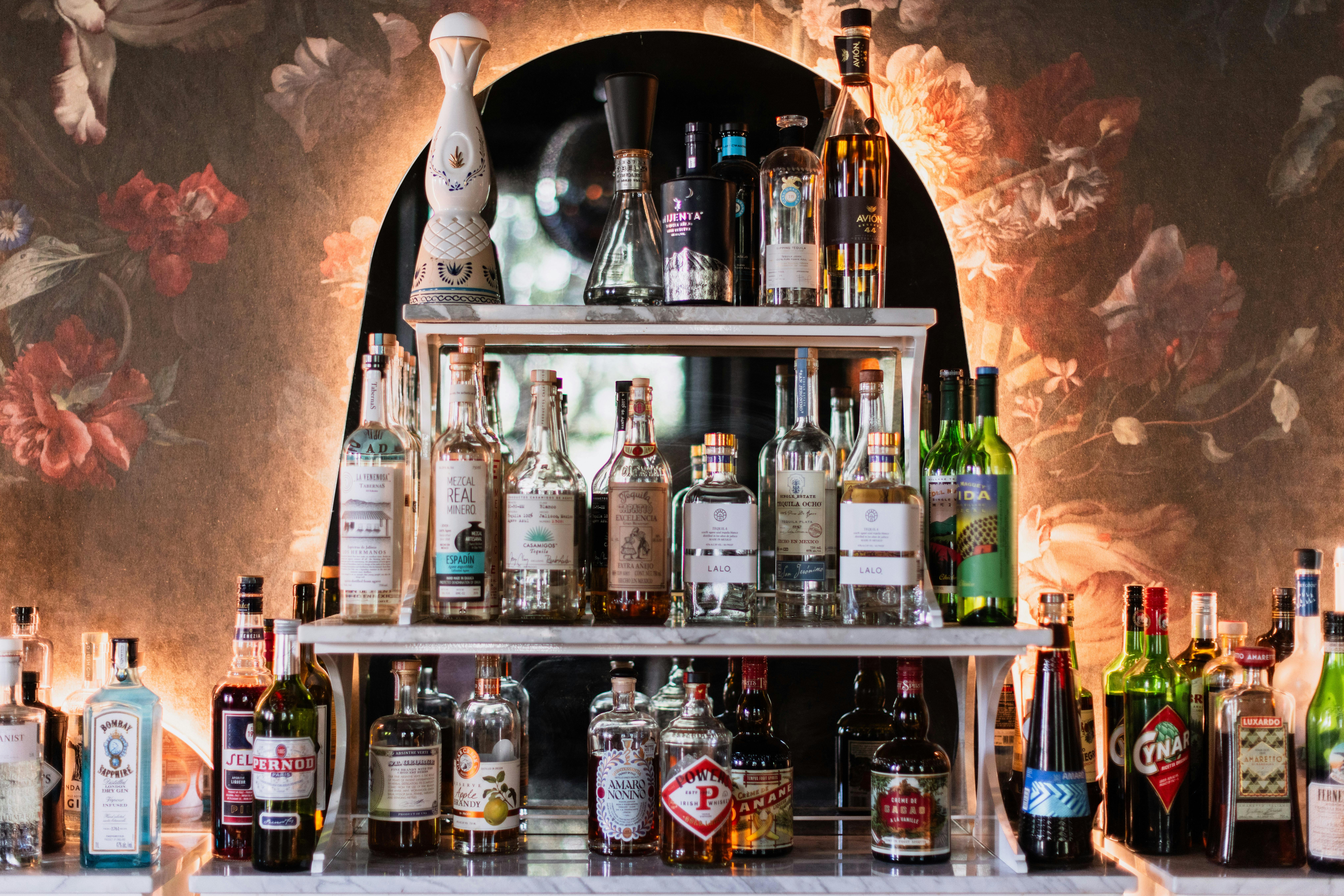 A bar with many bottles of alcohol on display · Free Stock Photo