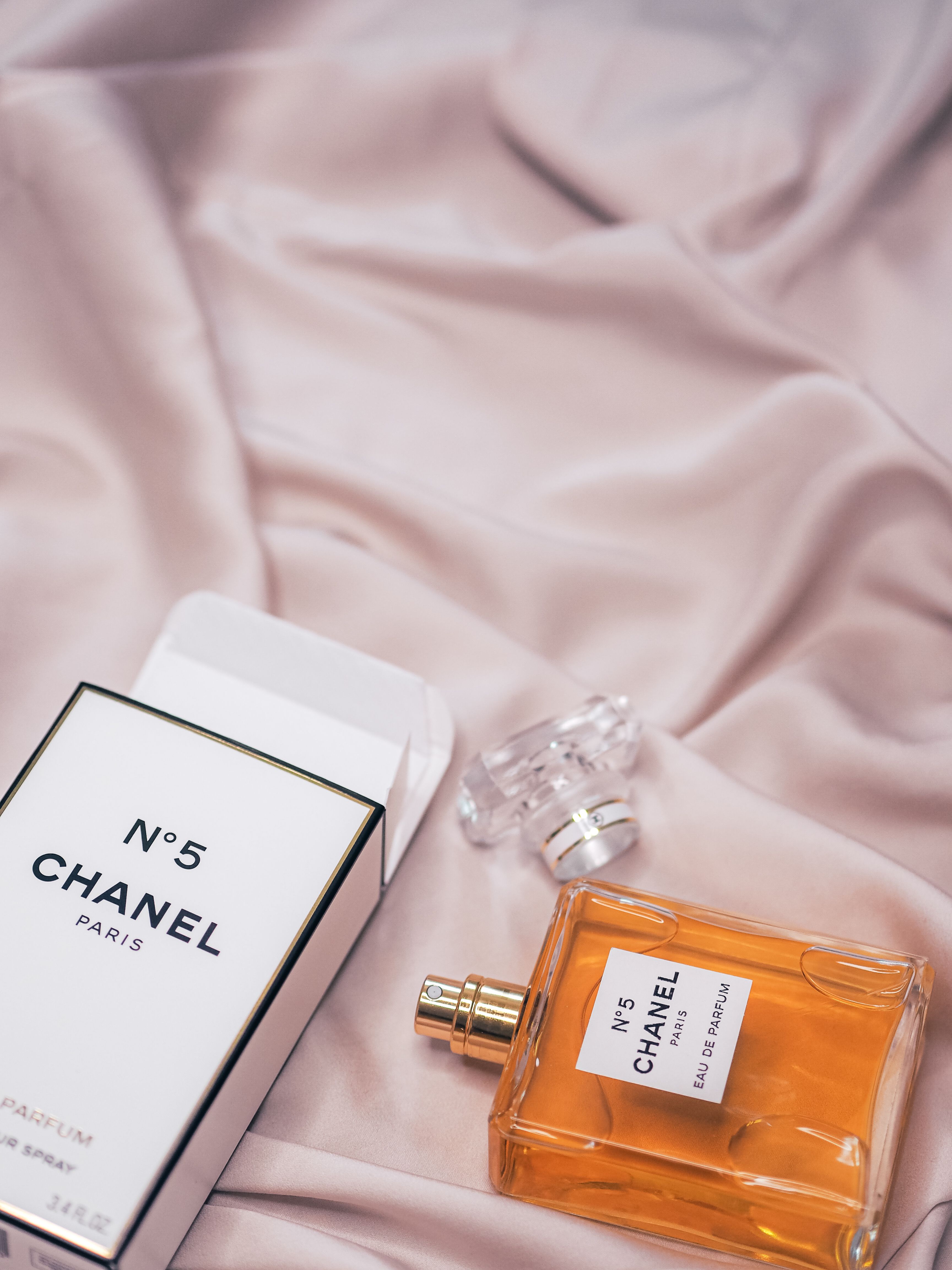Chanel perfume bottle and box on a pink cloth · Free Stock Photo