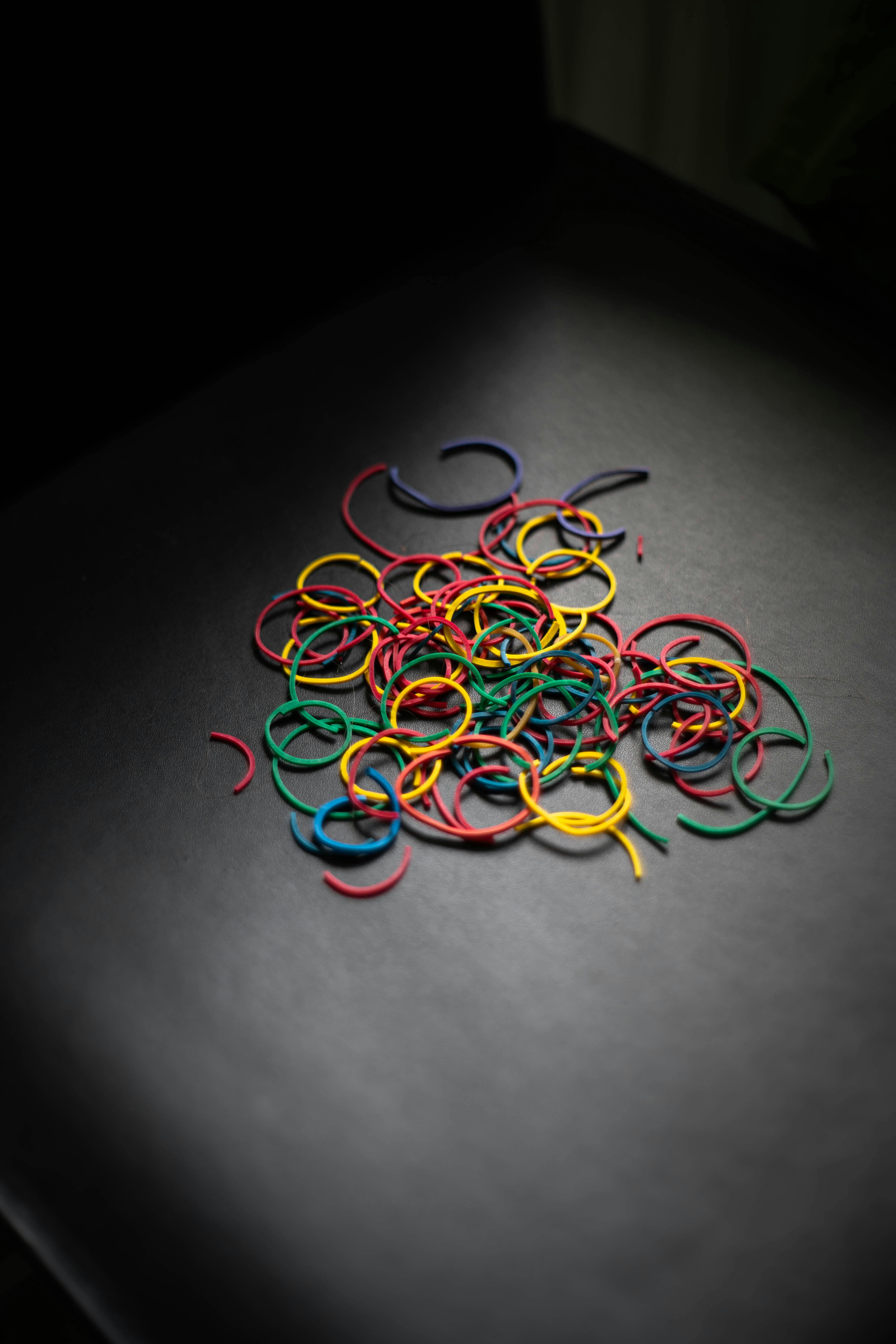 Colorful Broken Rubber Bands on Black Surface · Free Stock Photo