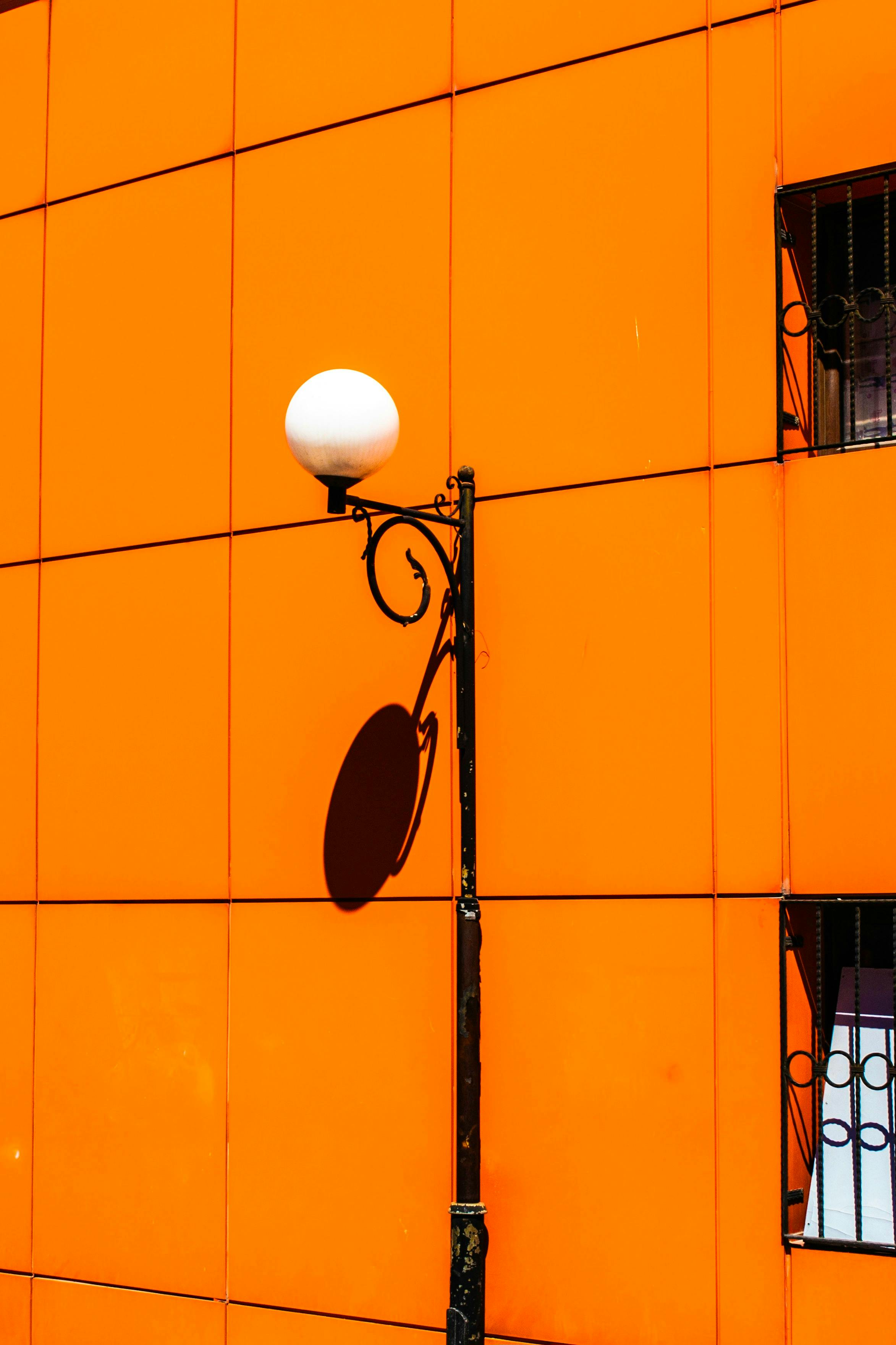 A Streetlight Attached to a Bright Orange Building · Free Stock Photo