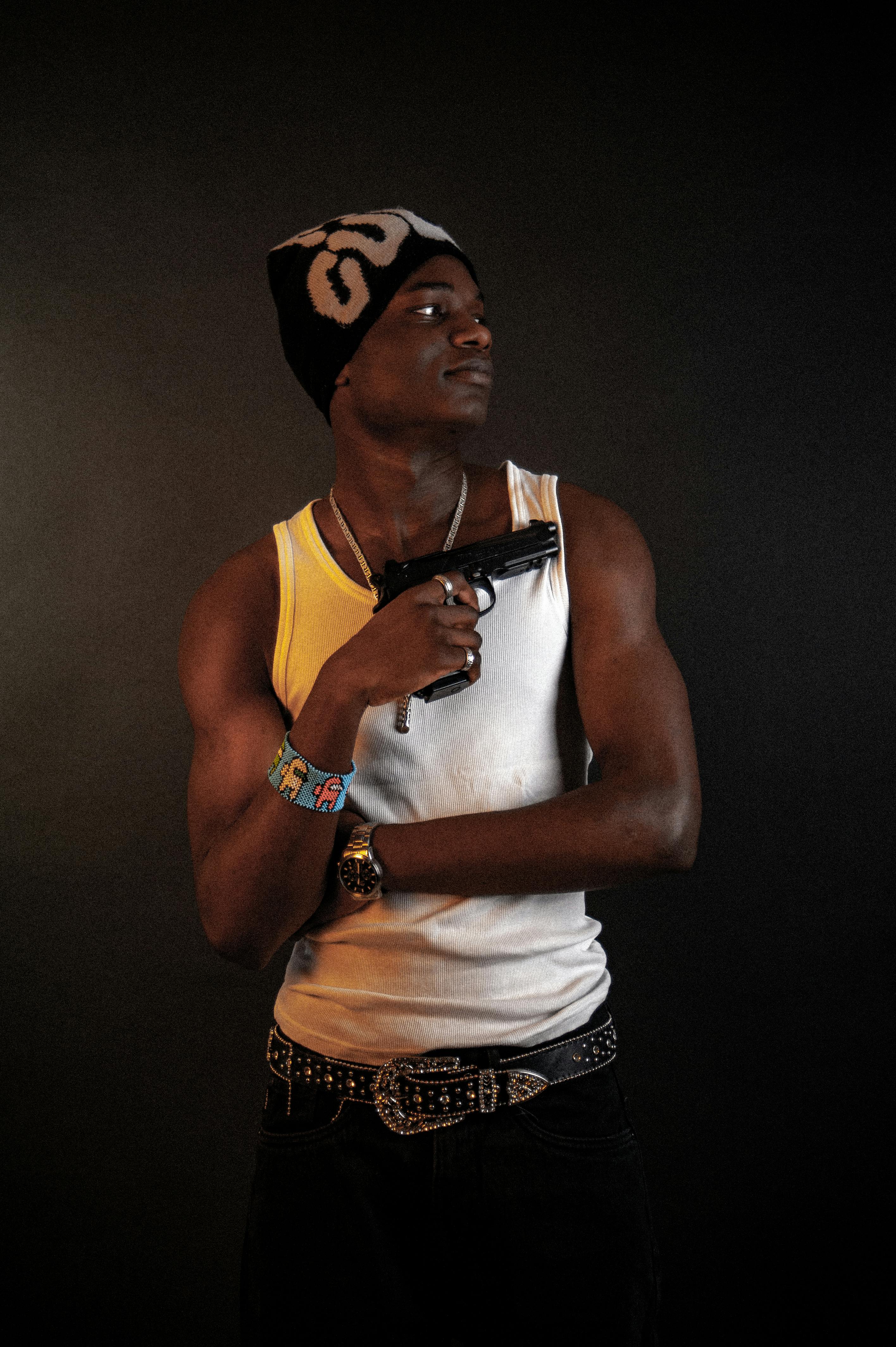 Studio Portrait of a Young Man Holding a Gun · Free Stock Photo