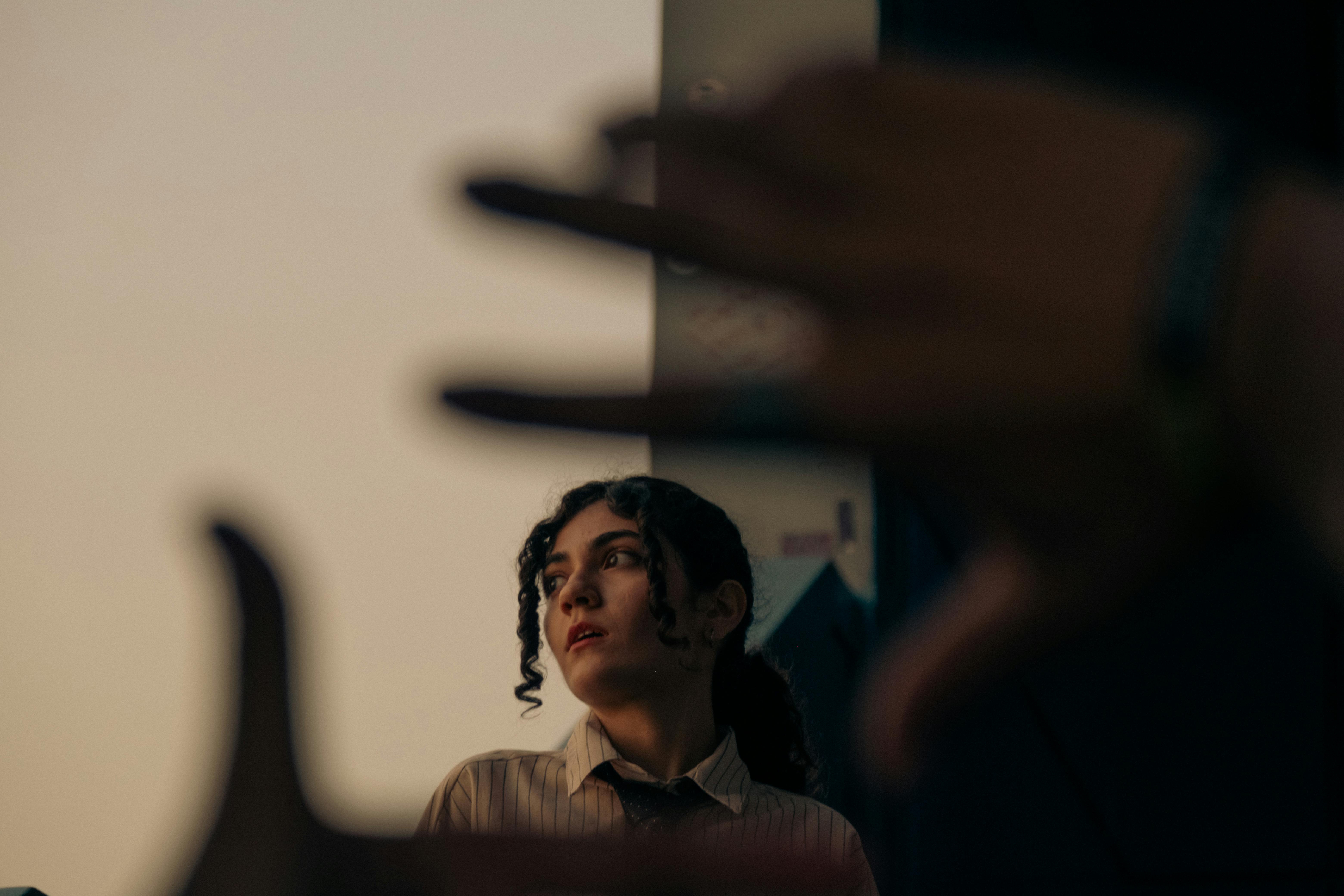 Brunette Woman behind Person Hands · Free Stock Photo