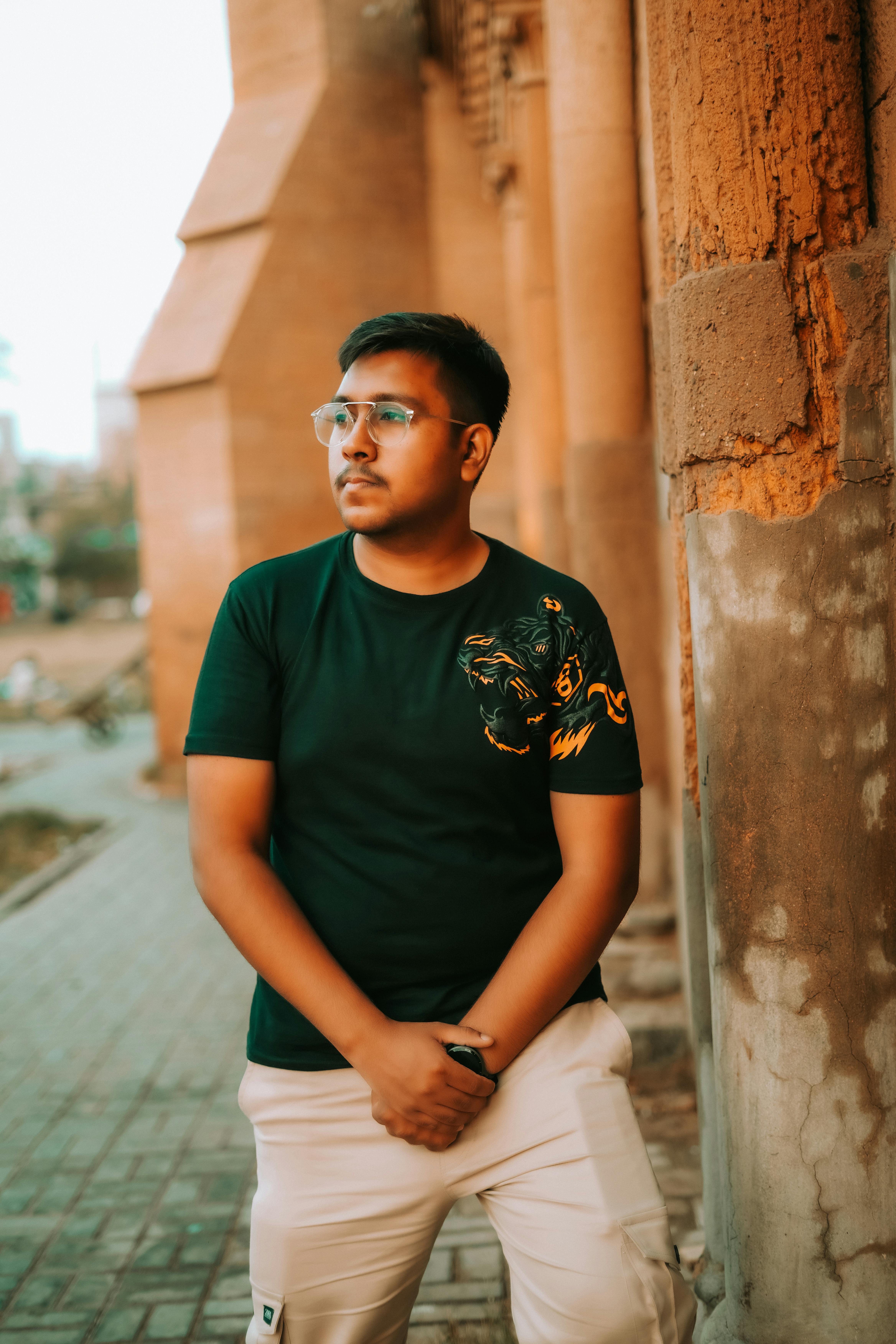 Man Posing next to an Orange Building · Free Stock Photo